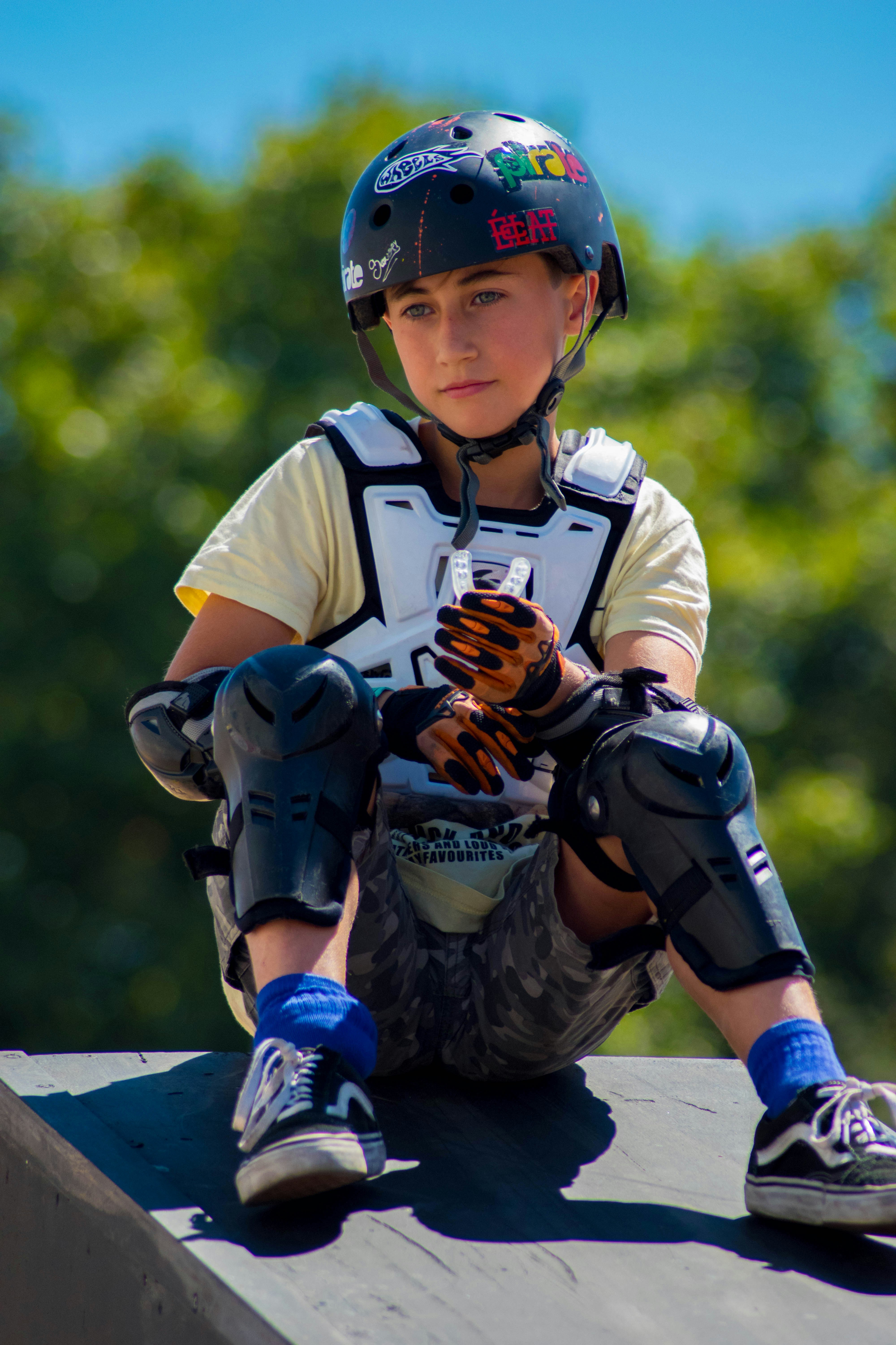 Kneeled Skater in Protective Gear Calculates a Move on the Ramp
