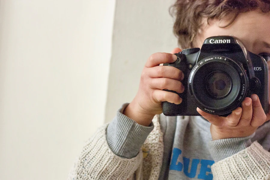 A self-portrait taken by my son when he was 6 years old | boy holding Canon DSLR camera