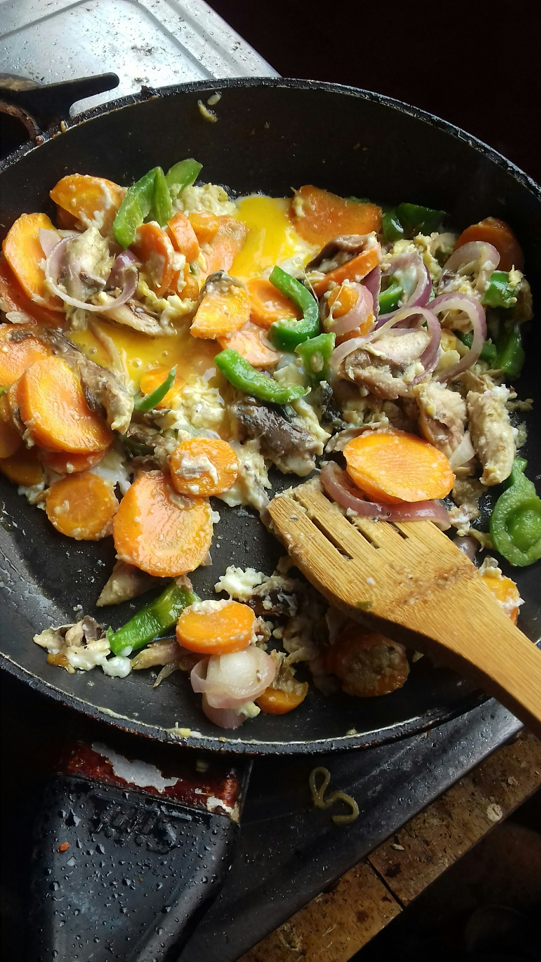 Skillet medley: vibrant vegetables and eggs cooking in a seasoned pan
