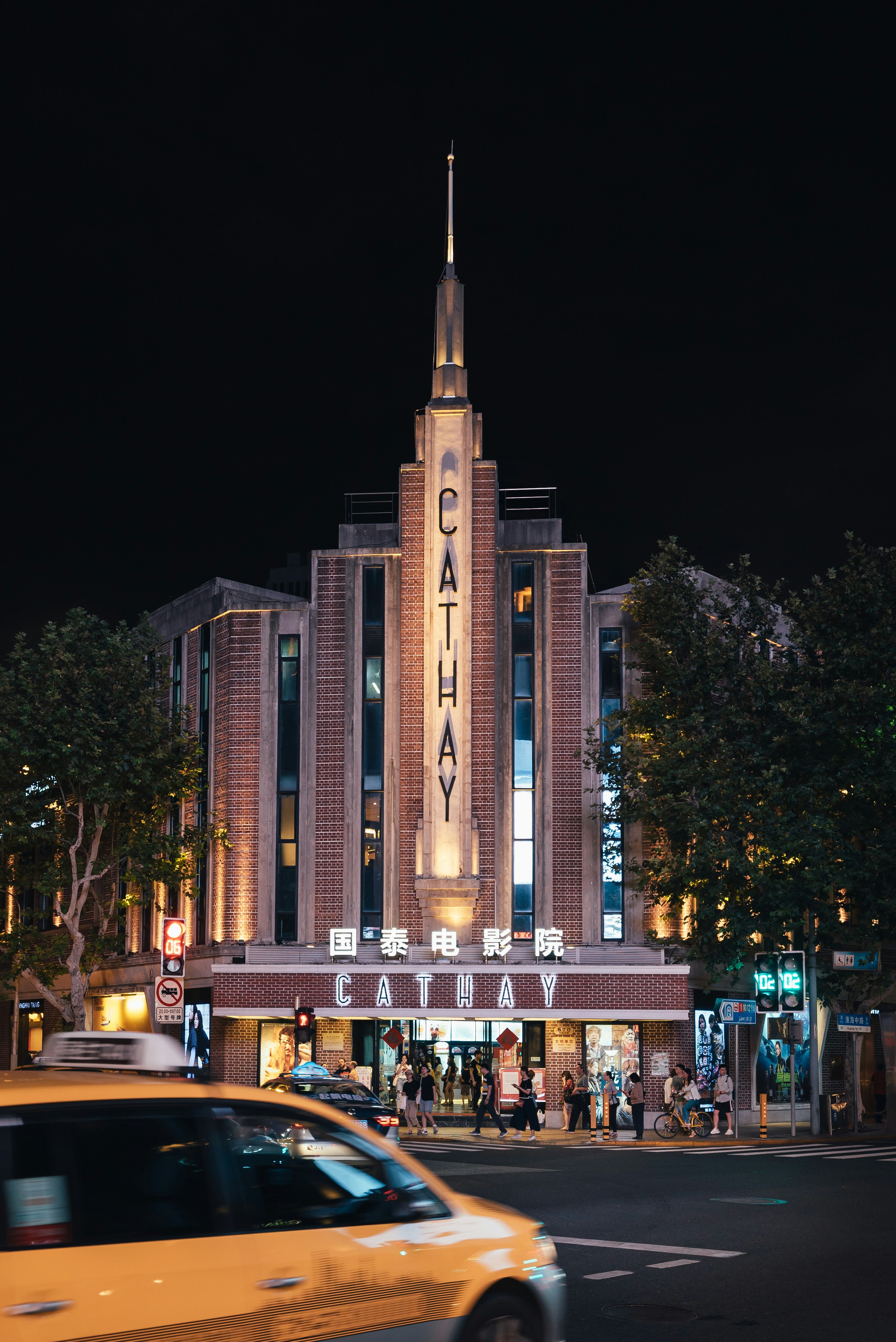 Cathay at Night: Neon-Warmed Theater Facade Framed by City Traffic