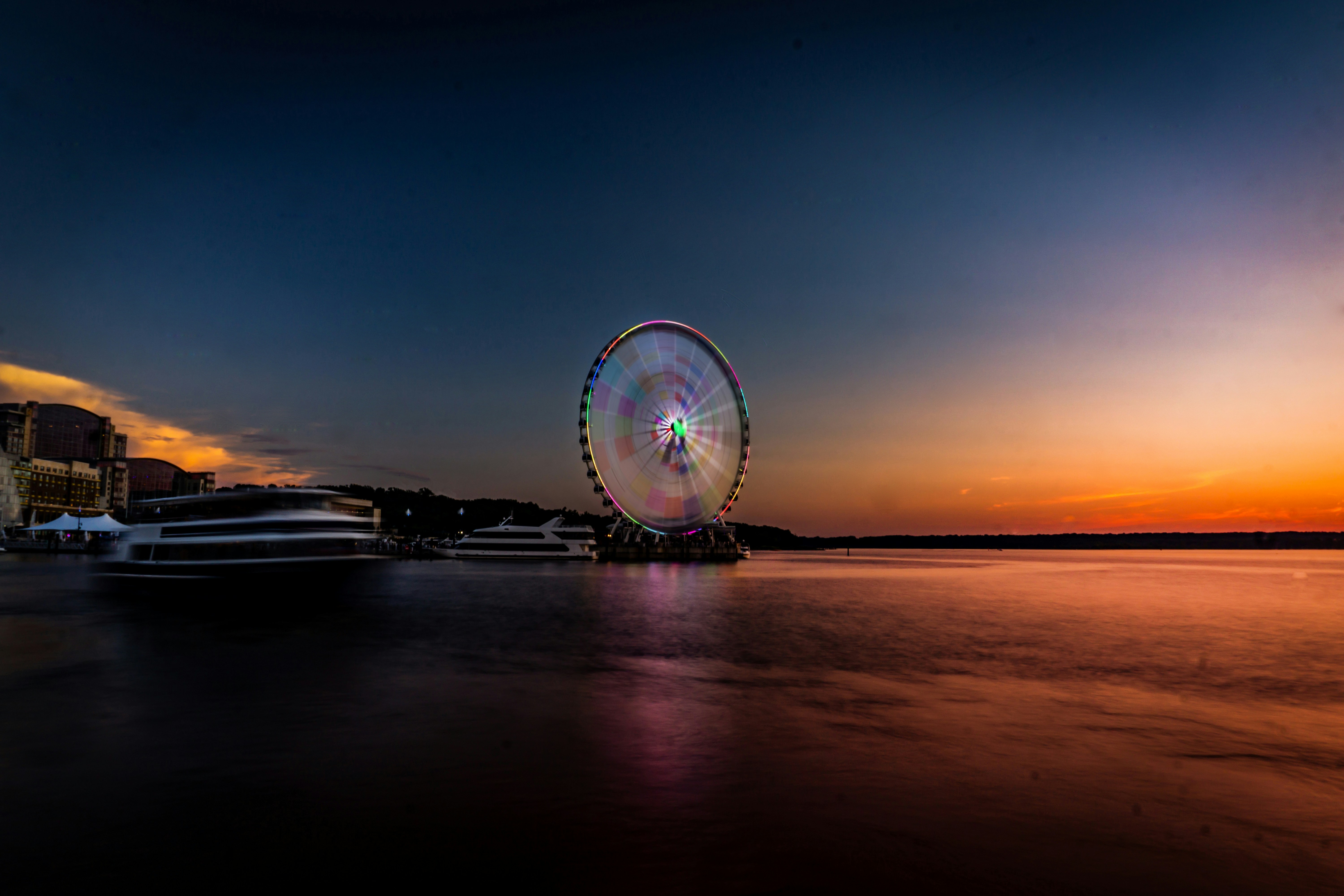 Dusk Carousel Over the River: A Neon Ferris Wheel at Sunset