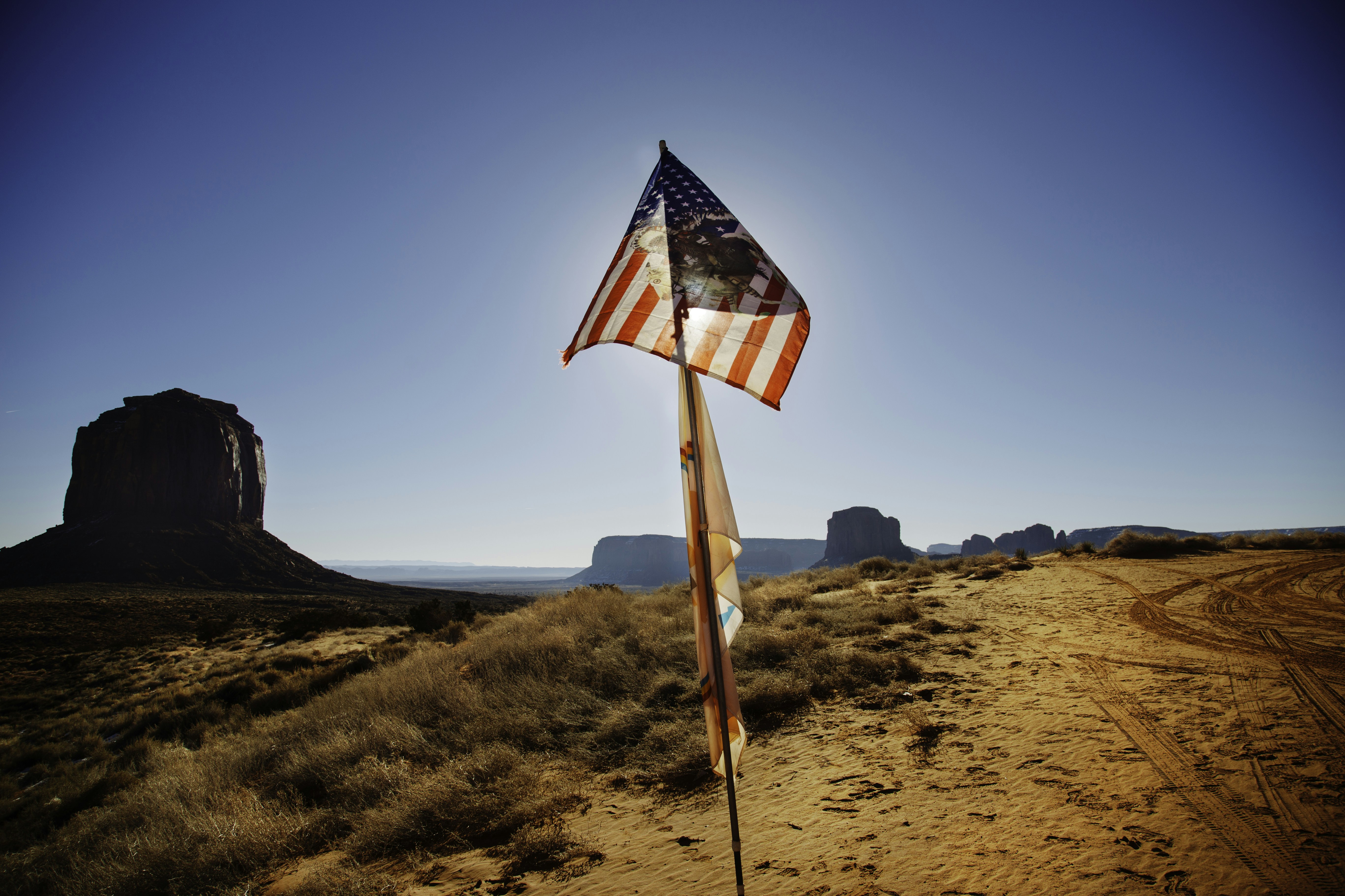 Flag on a Wind-Scoured Desert Ridge Framing Distant Mesas