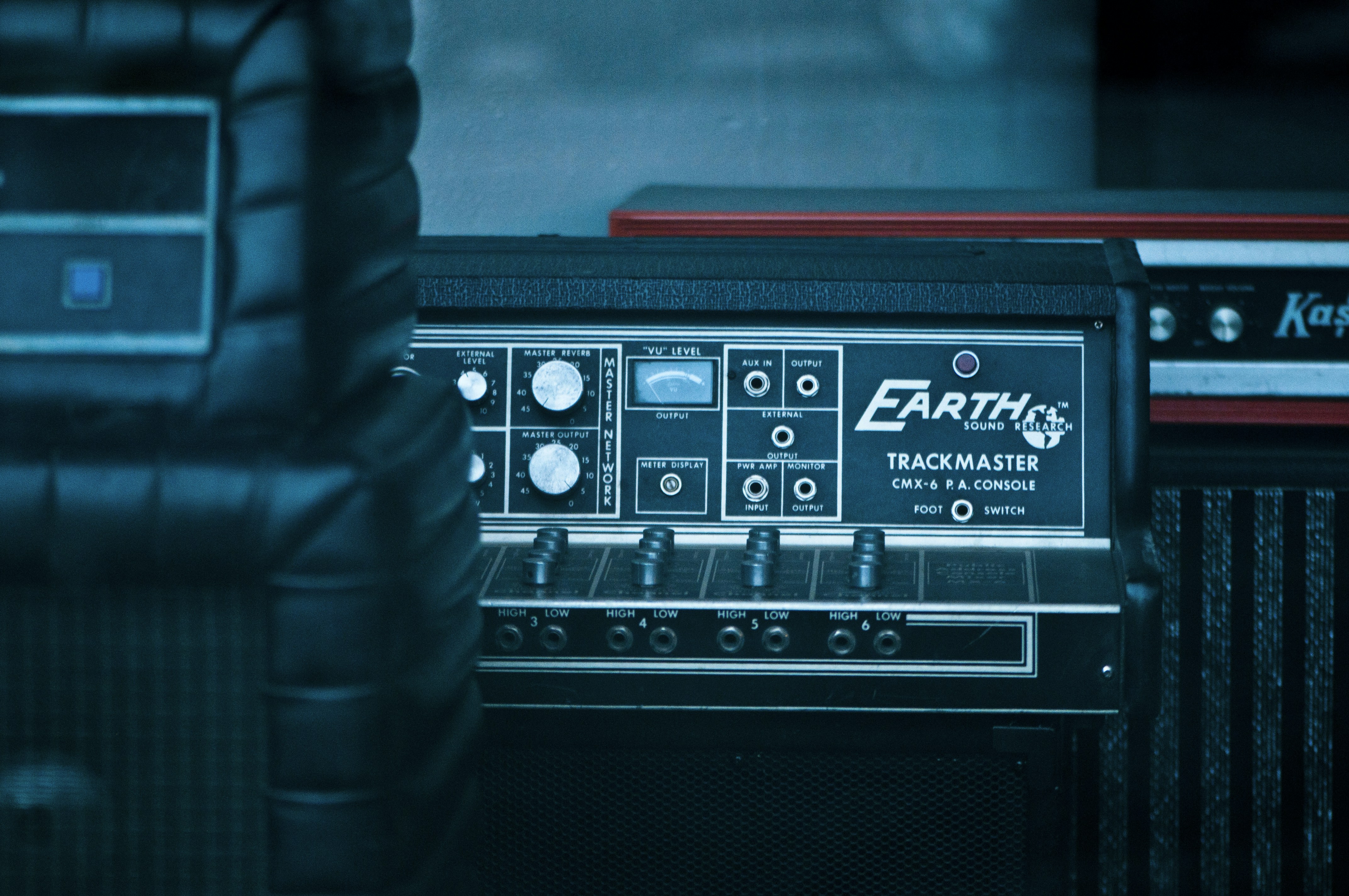 Earth Trackmaster mixing console surrounded by amplifiers in a studio setting.