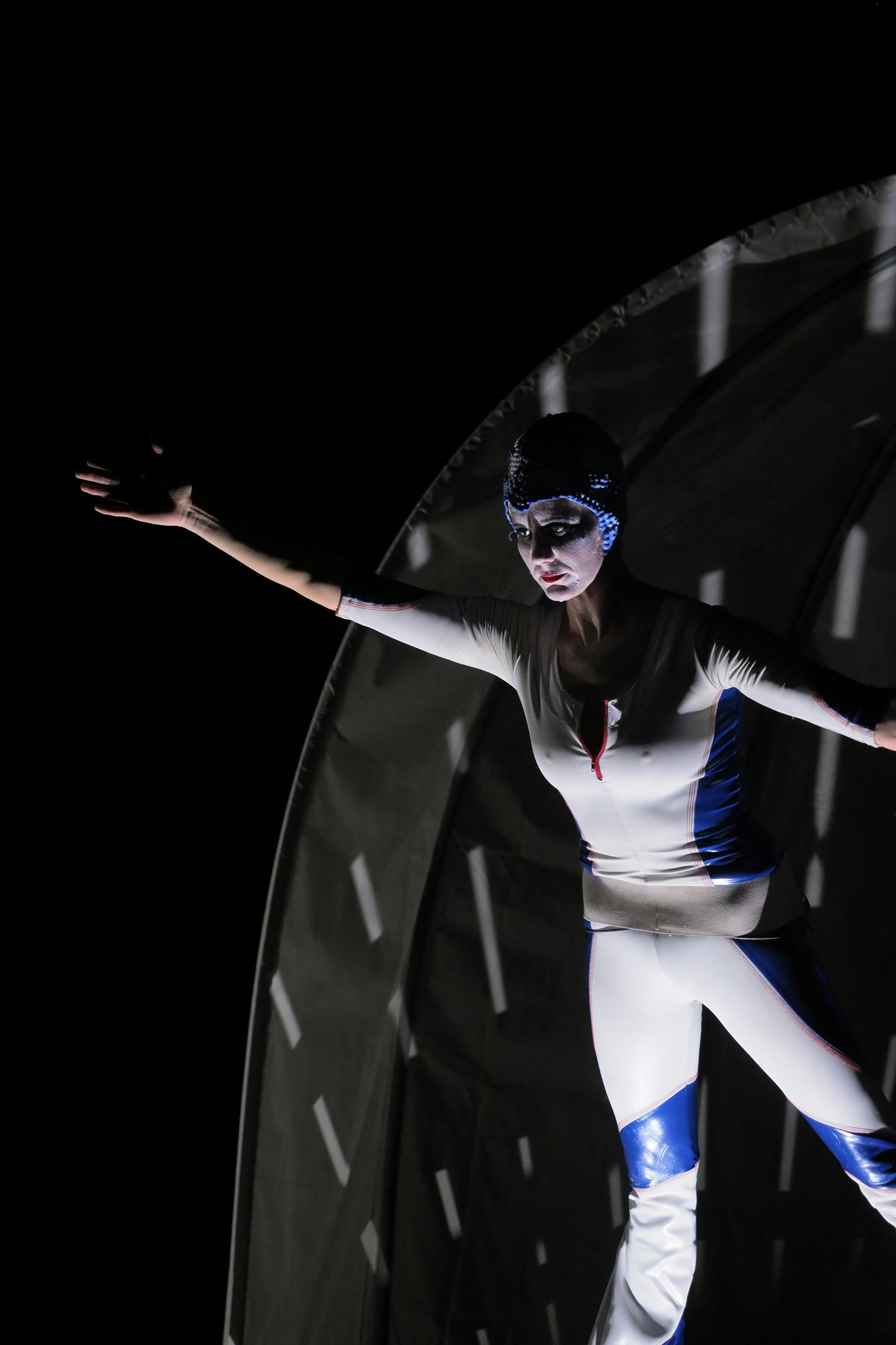 Ringed Night: Acrobat in a Circular Frame Under Neon-Blue Spotlight