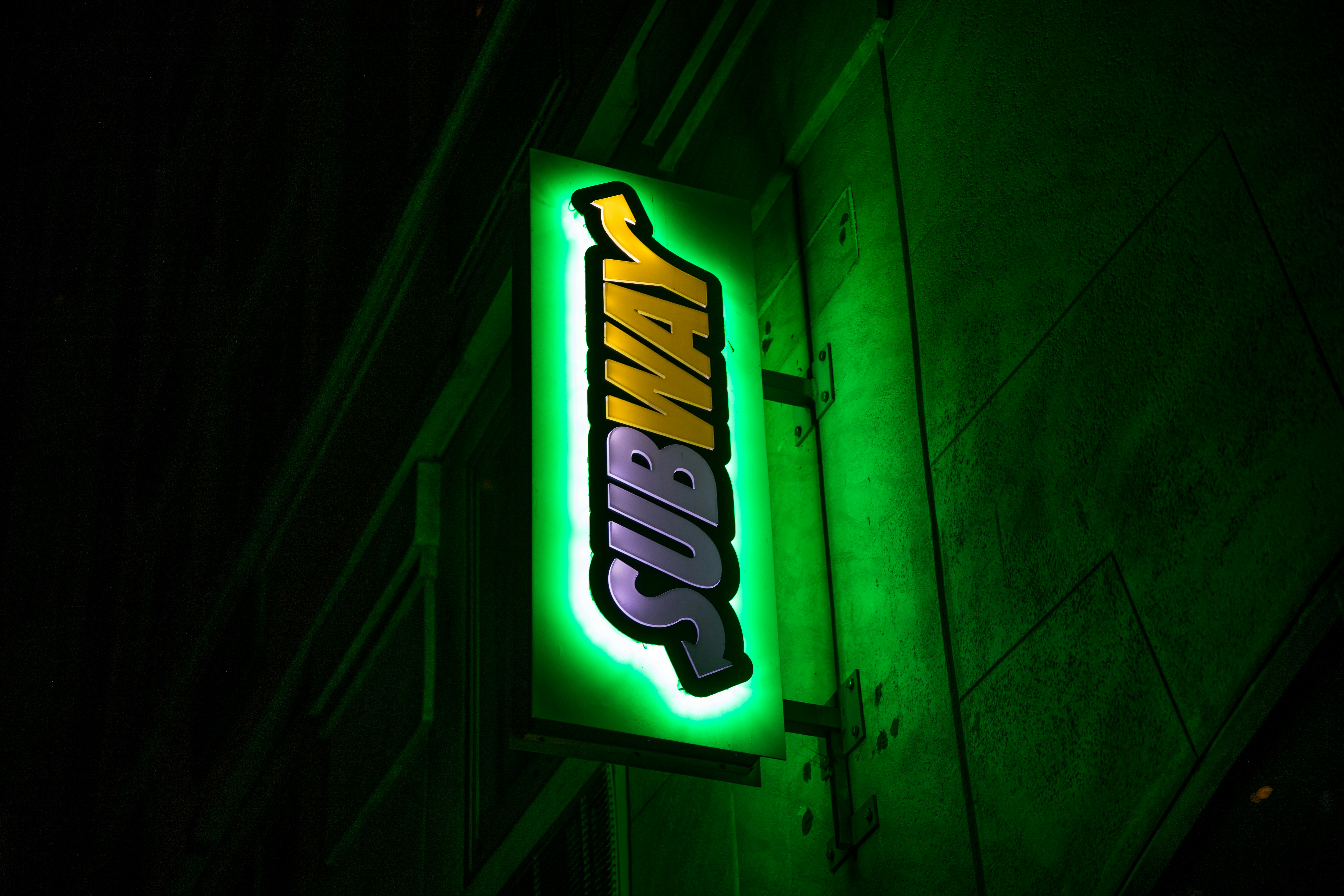 Emerald Neon: The Subway Sign Quietly Illuminates the Night
