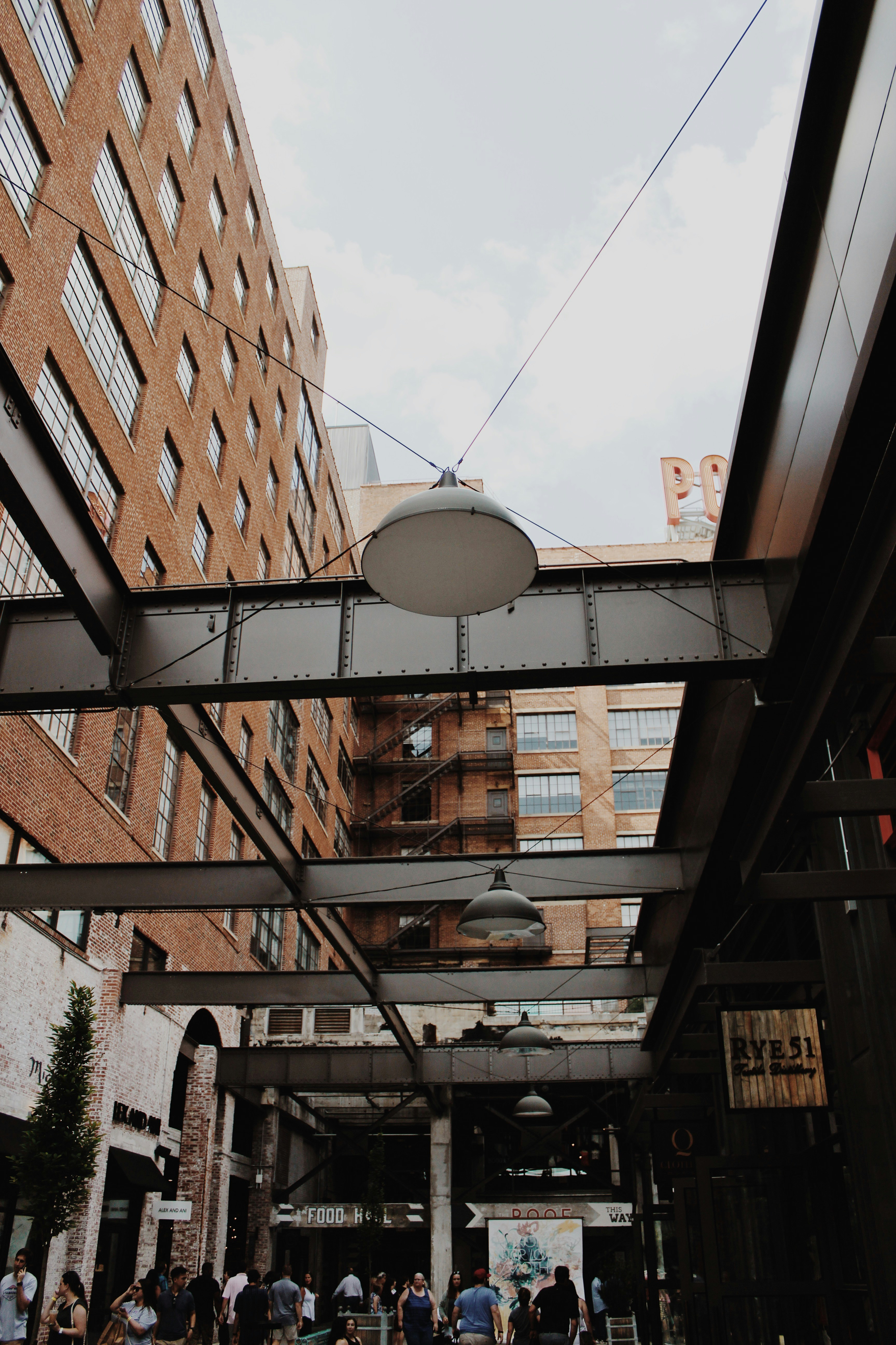 Lanterns, Steel, and Brick: A City Courtyard Under a Walkway