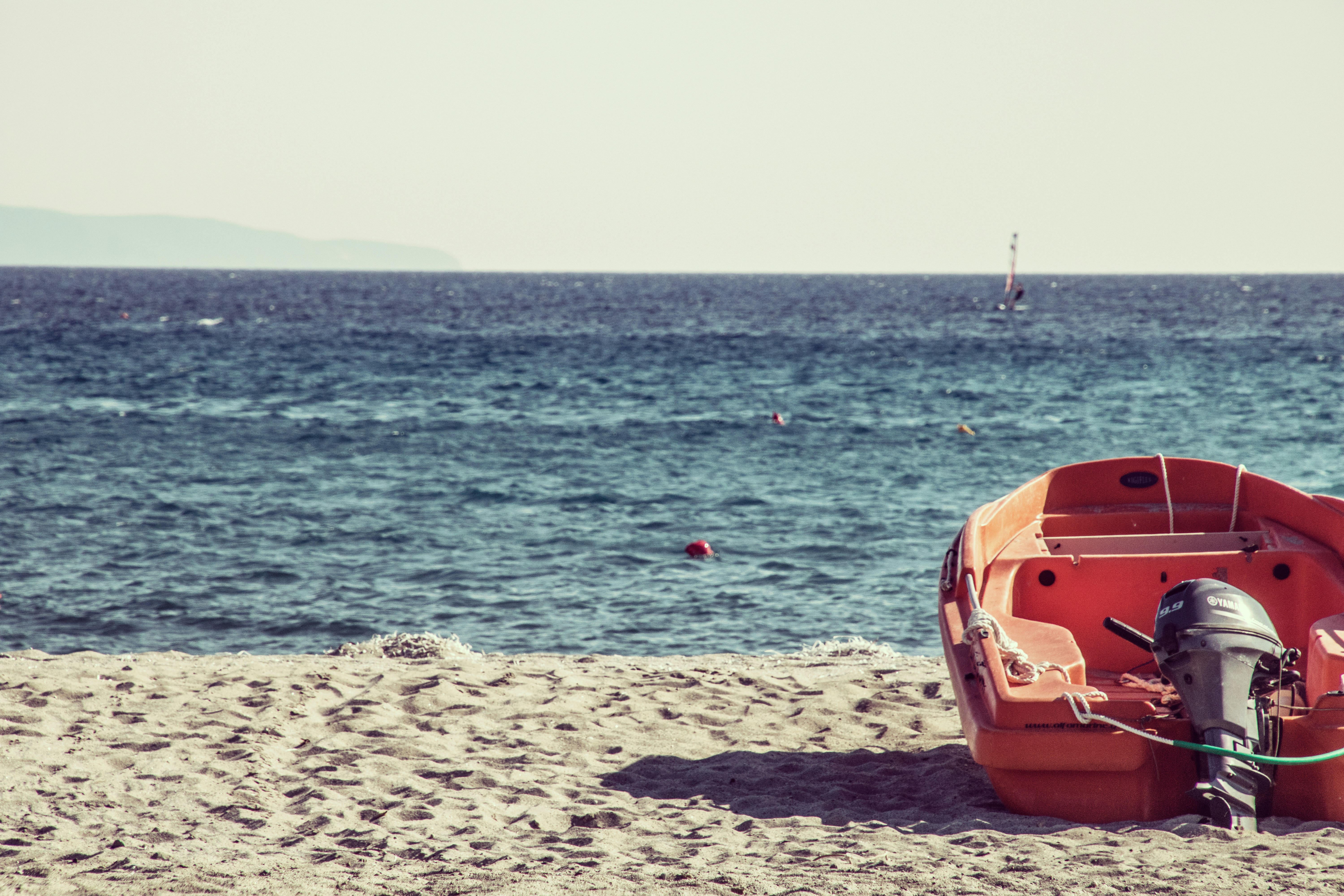 red speedboat on seashore during daytime