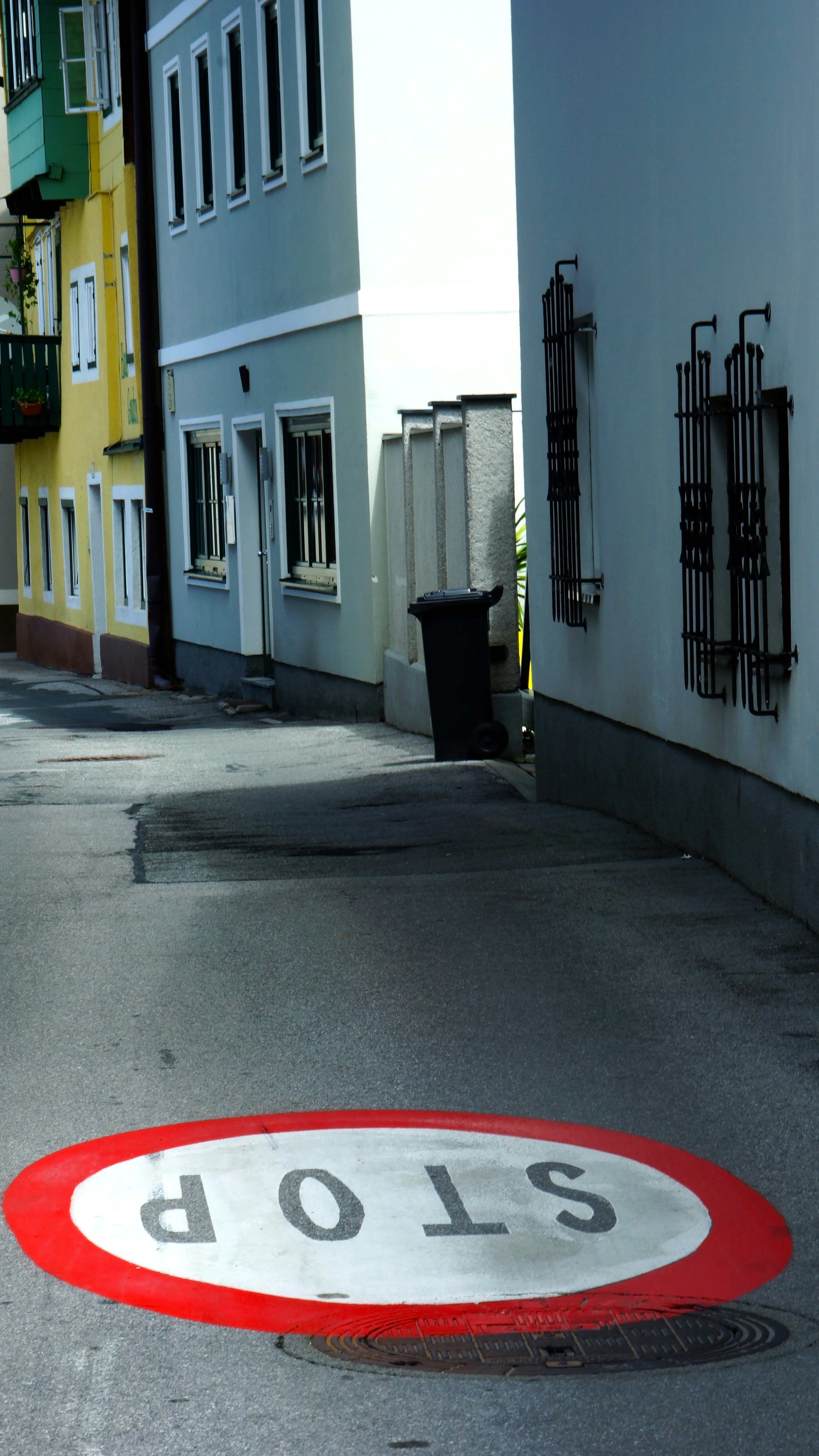 Stop Sign Over a Pastel Street: A Quiet Alley Framed by Colorful Facades