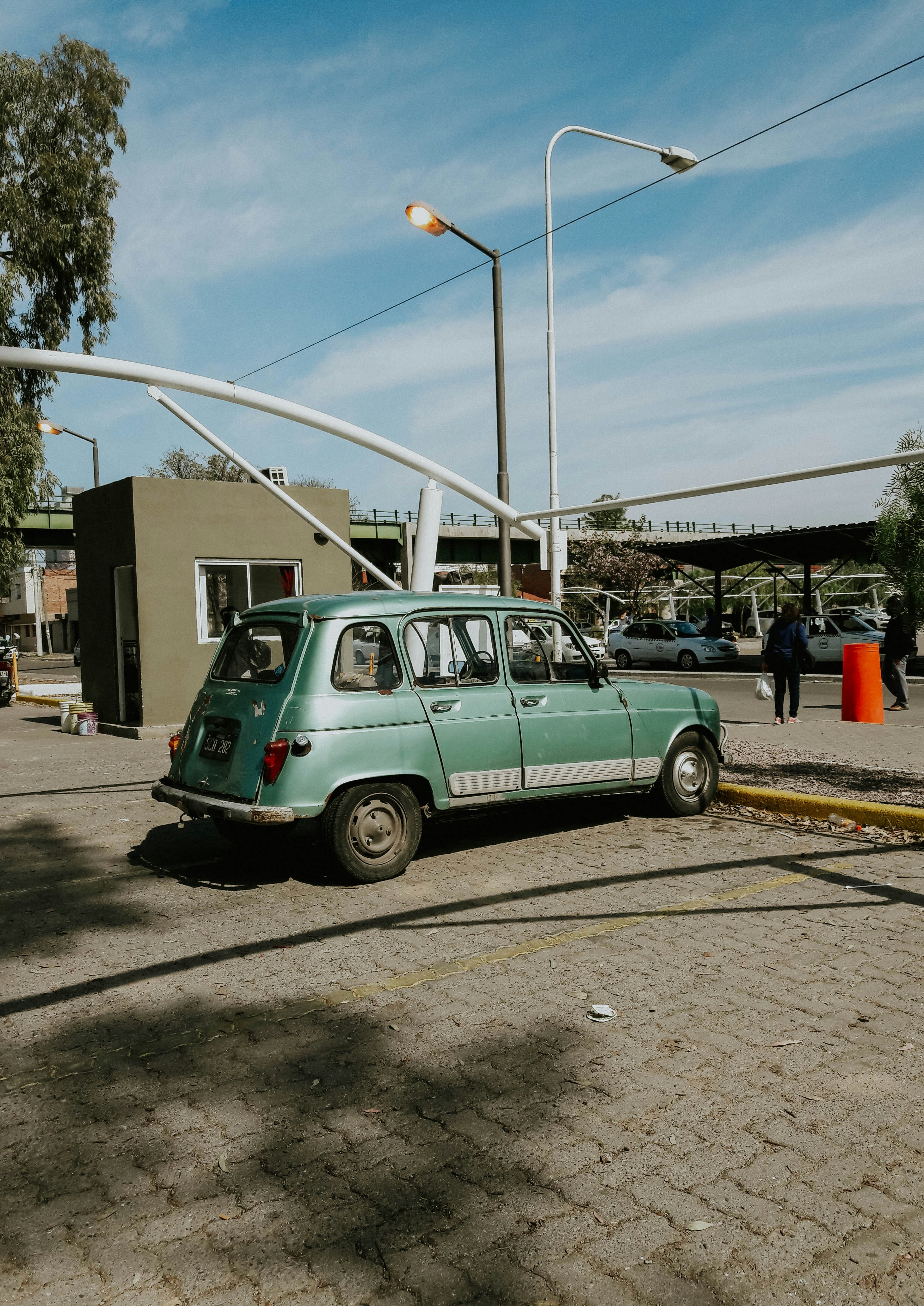 Classic green car parked near modern architecture, showcasing a blend of vintage and contemporary styles.