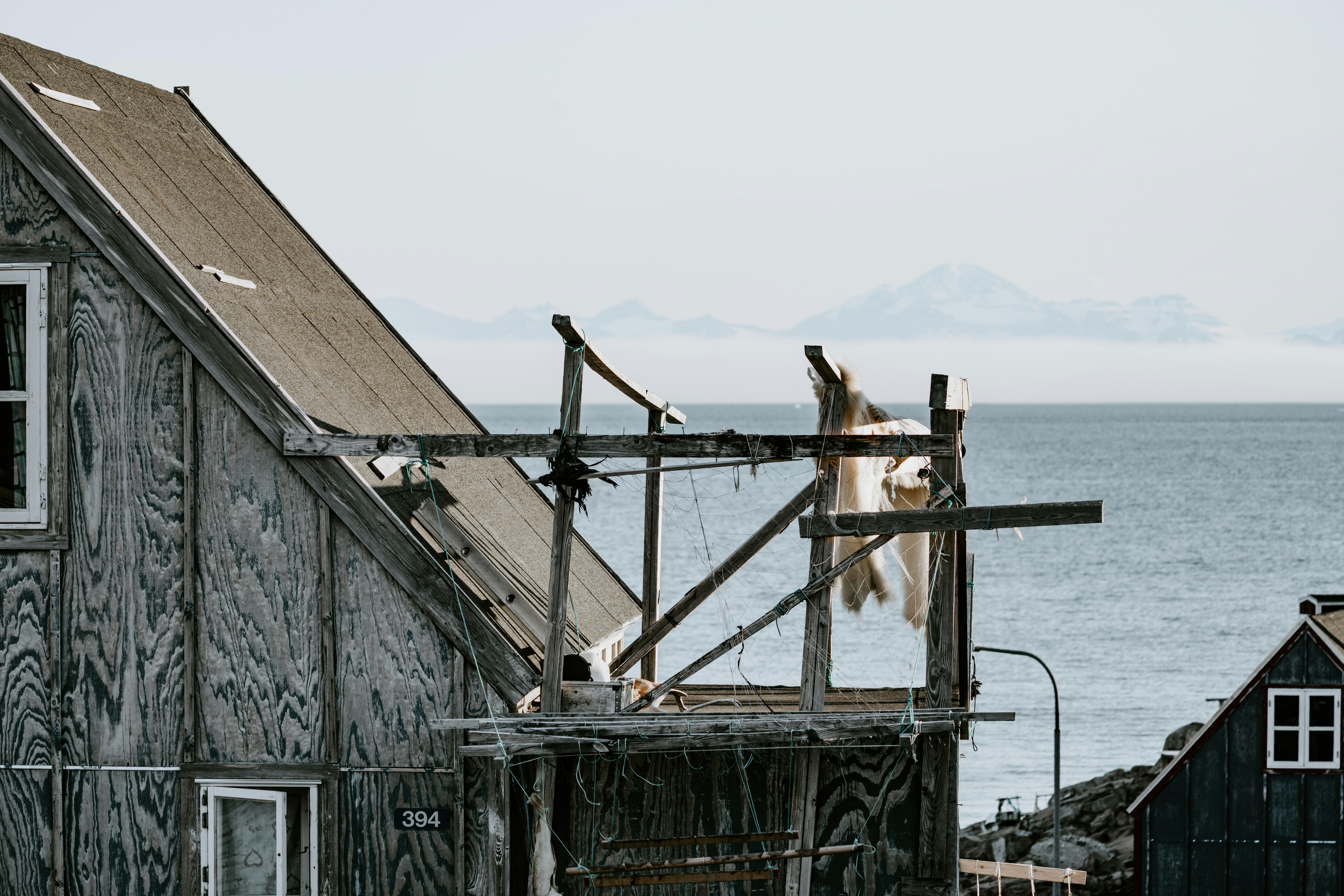 Goat at the Edge: Weathered Balcony Over a Calm Coastal Stretch