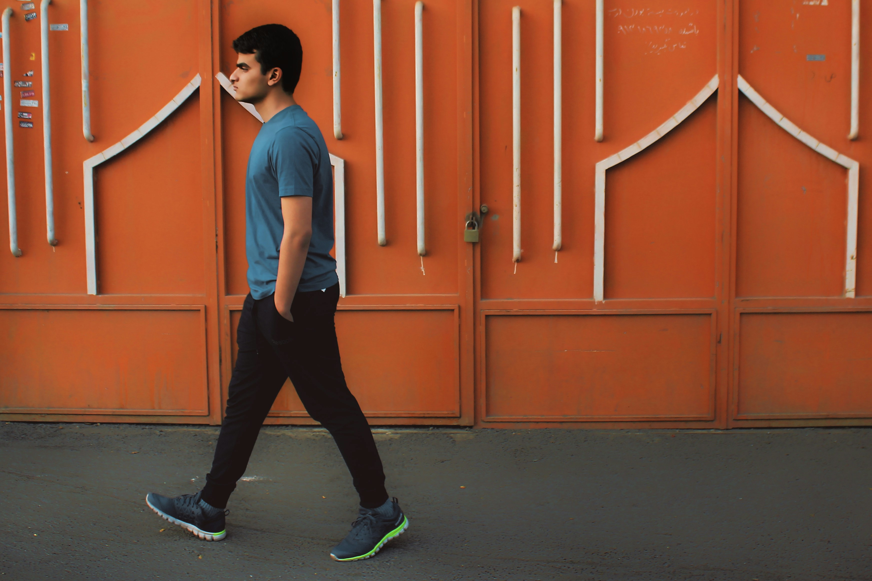 Man walking near orange and white gates photo – Free People Image on ...