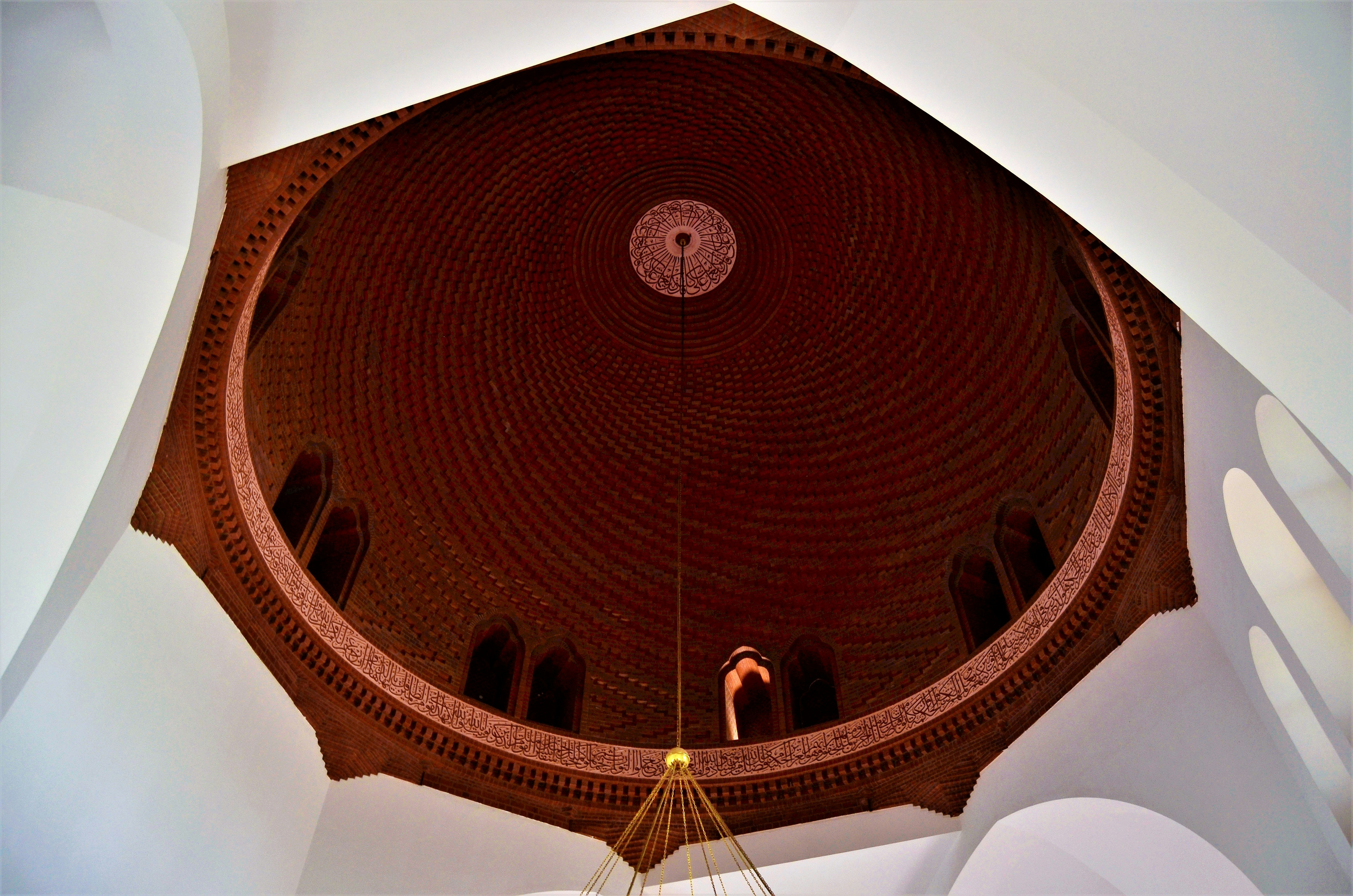 Dome of Echoes: A Circular Ceiling with Light Amid White Ramp Edges