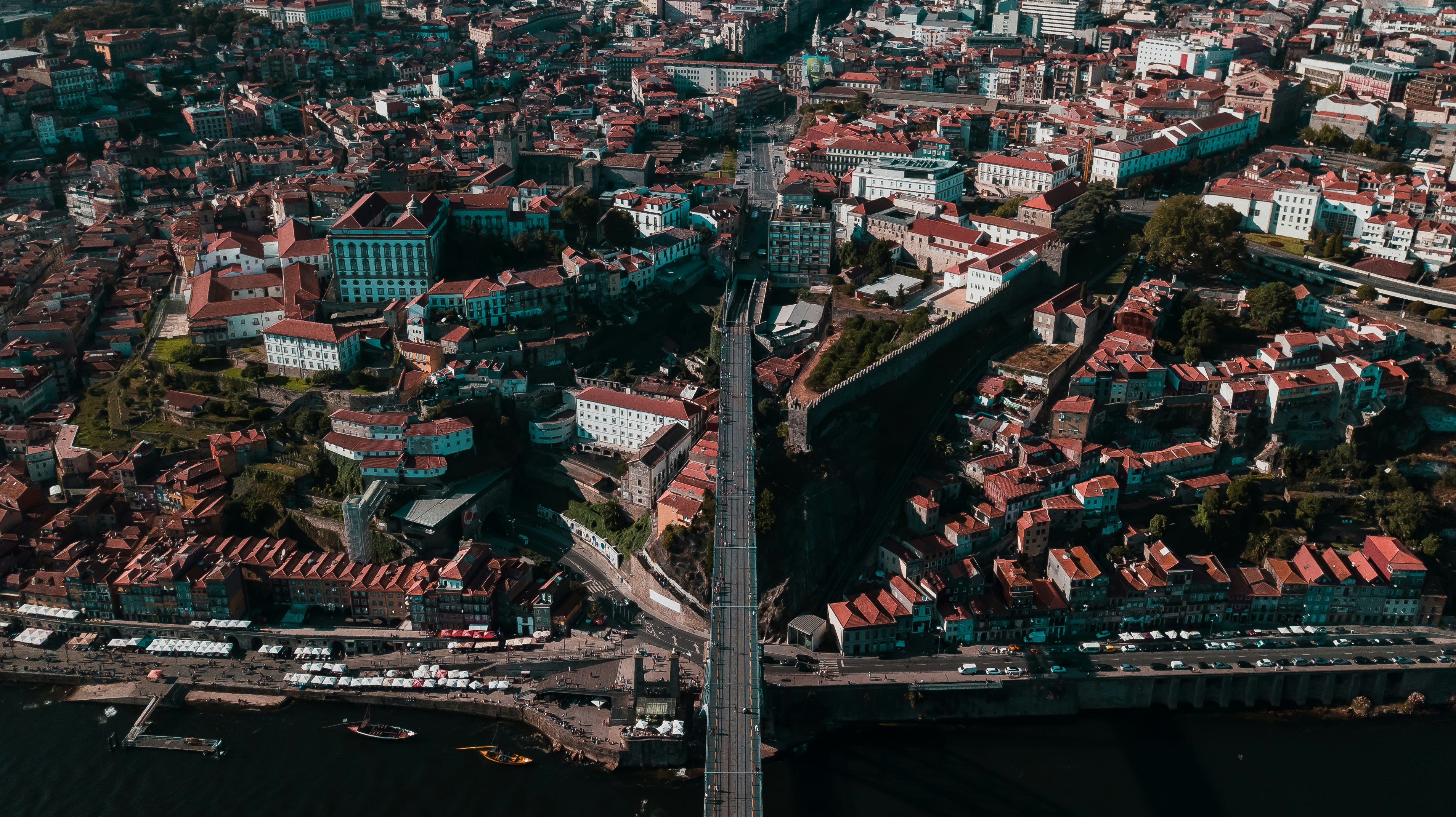 Aerial view of a long bridge spanning across a vibrant cityscape.