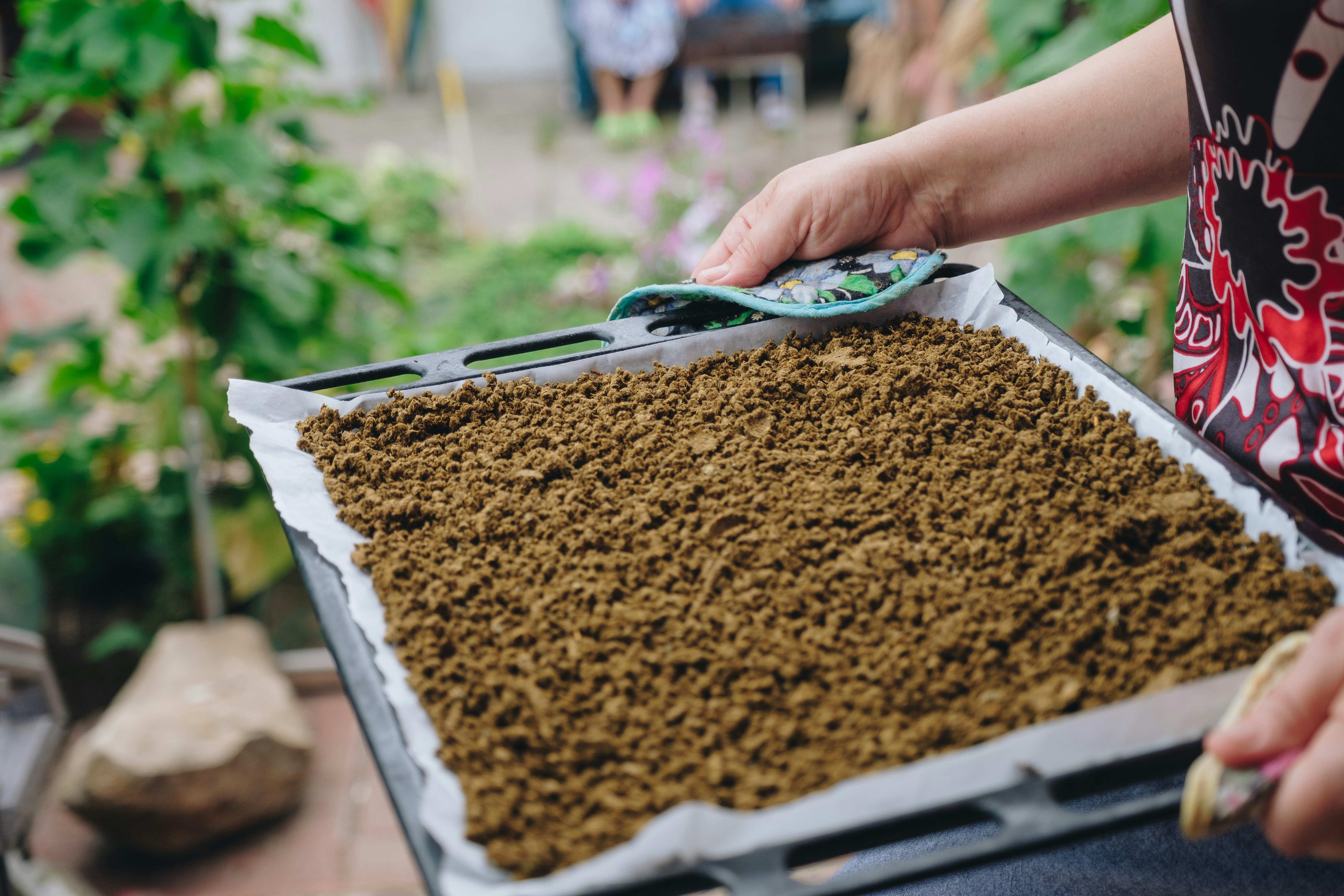 Tiny soil, big craft: hands sifting brown treasure