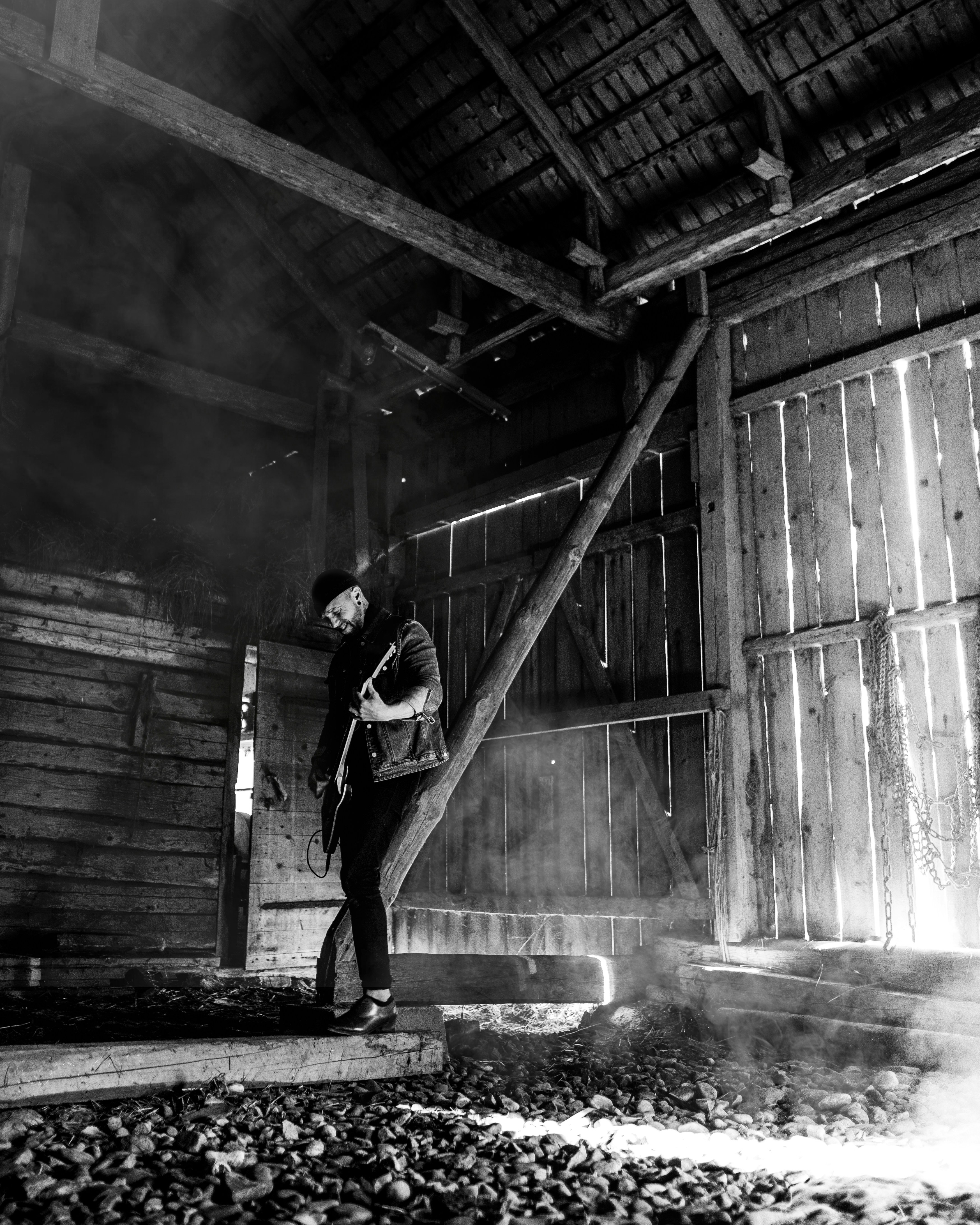 Strains in the Silhouette: A Guitarist in a Weathered Barn