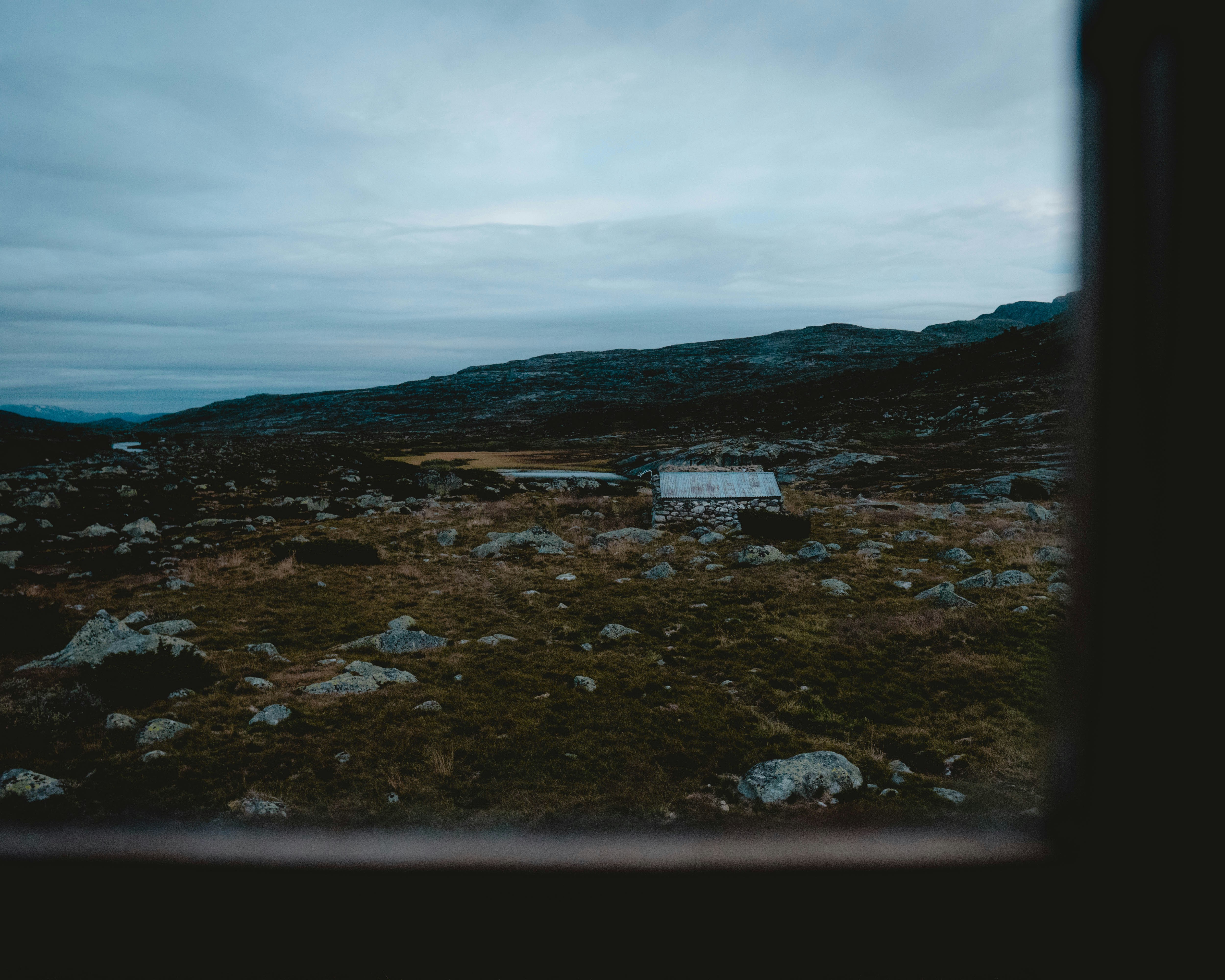 Moorland Bench Through a Window: Quiet, Wind-Swept Ridge