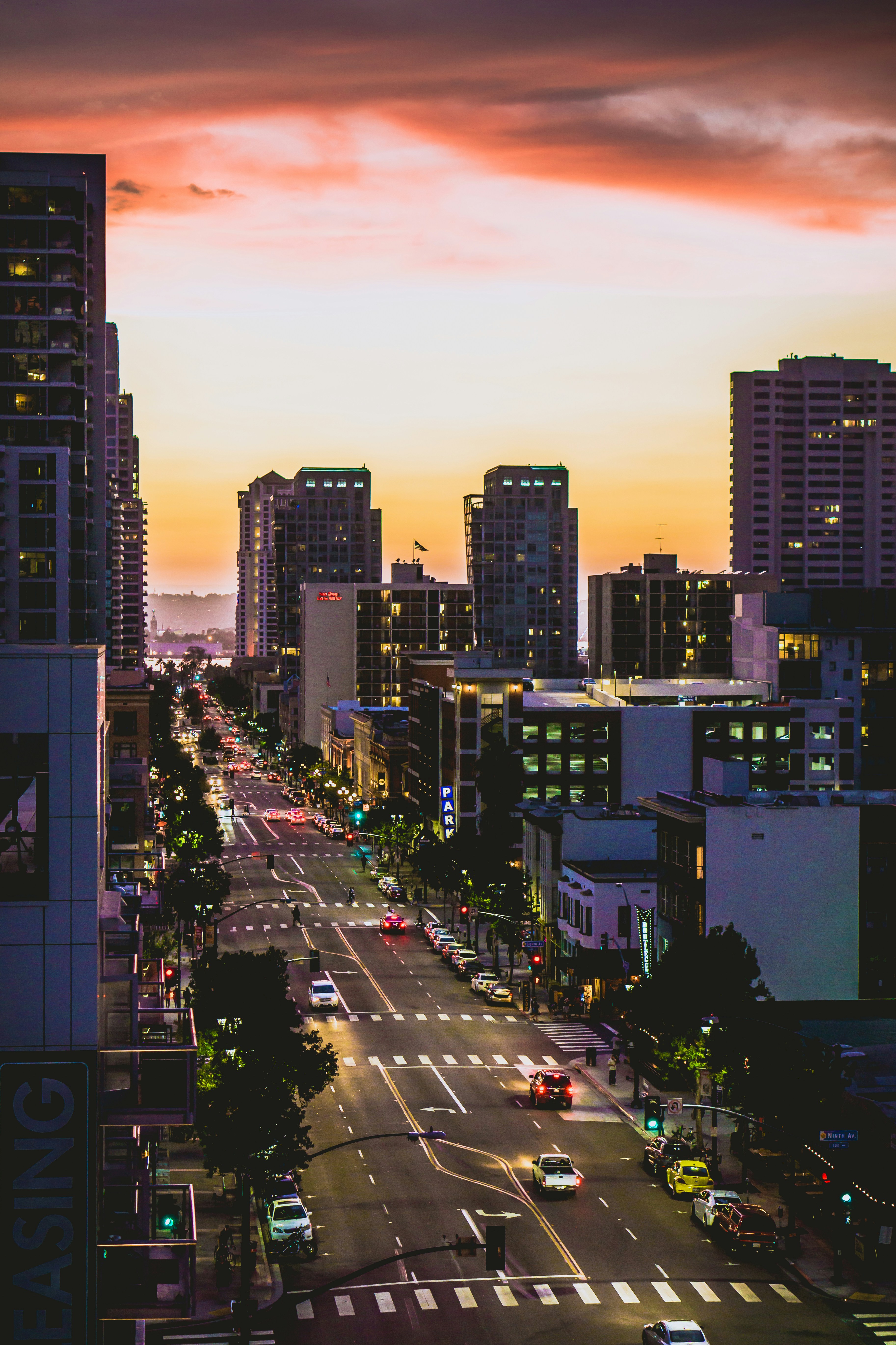 Sunset in San Diego | vehicle on paved road between high-rise buildings