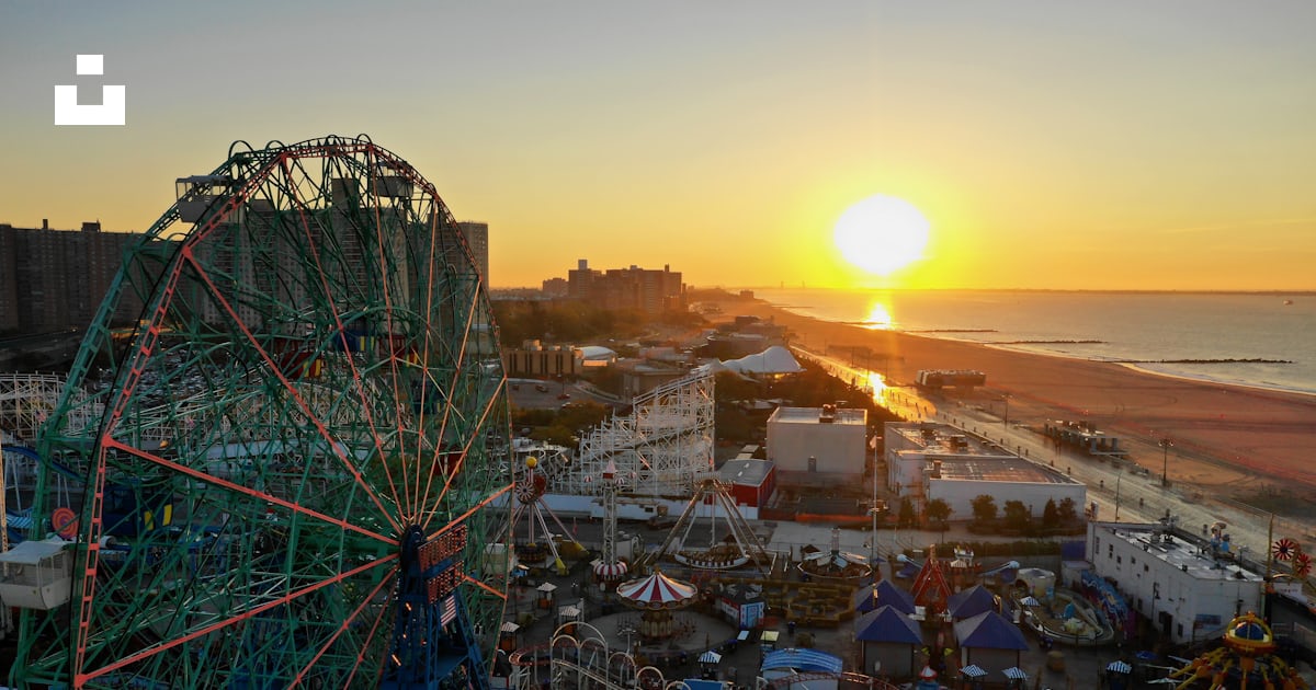 골든 아워golden Hour 동안 수역 근처의 관람차ferris Wheel의 항공 사진 사진 Unsplash의 무료