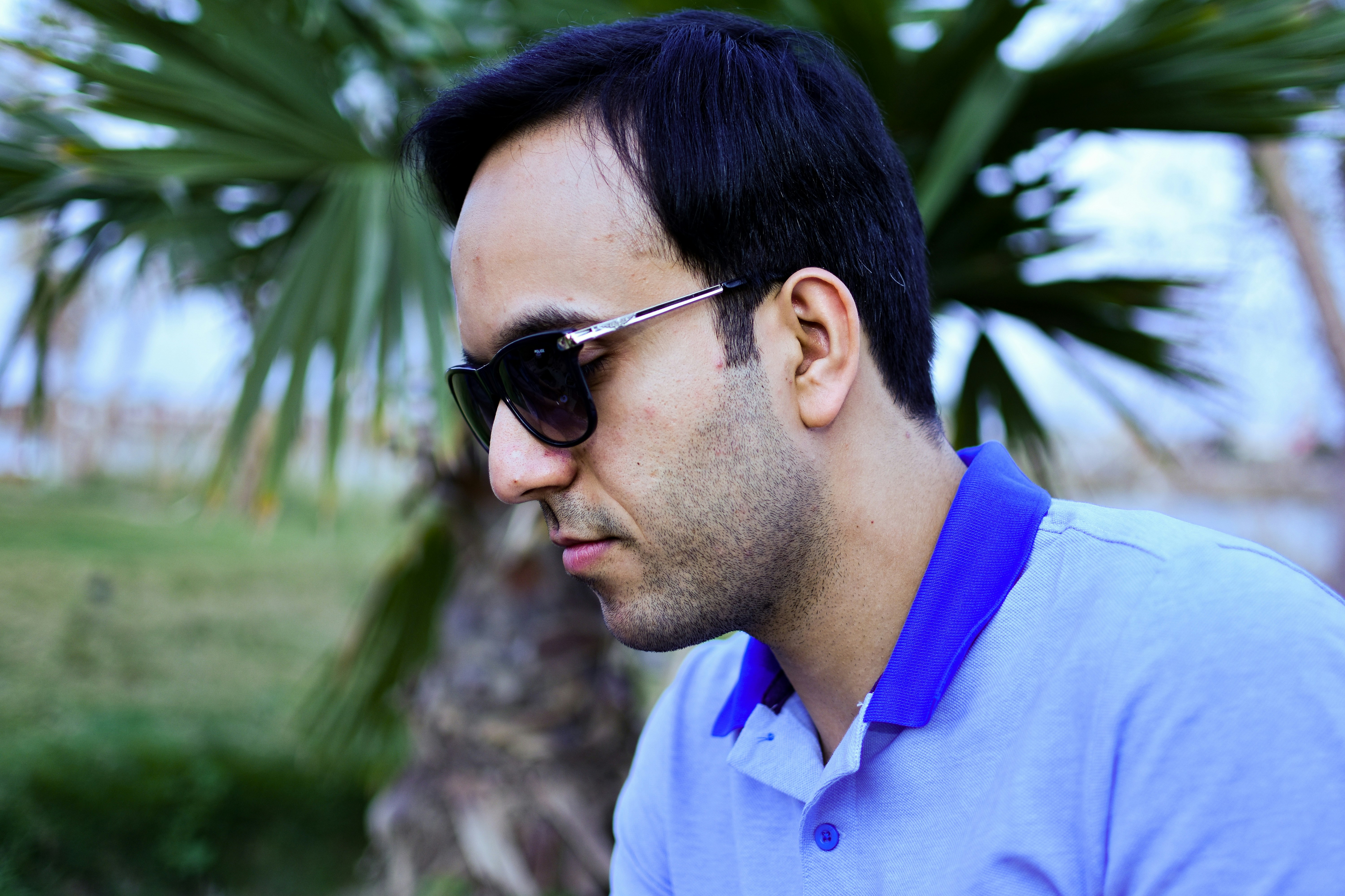 Profile in Shade: Palm Fronds Frame a Quiet Outdoor Portrait
