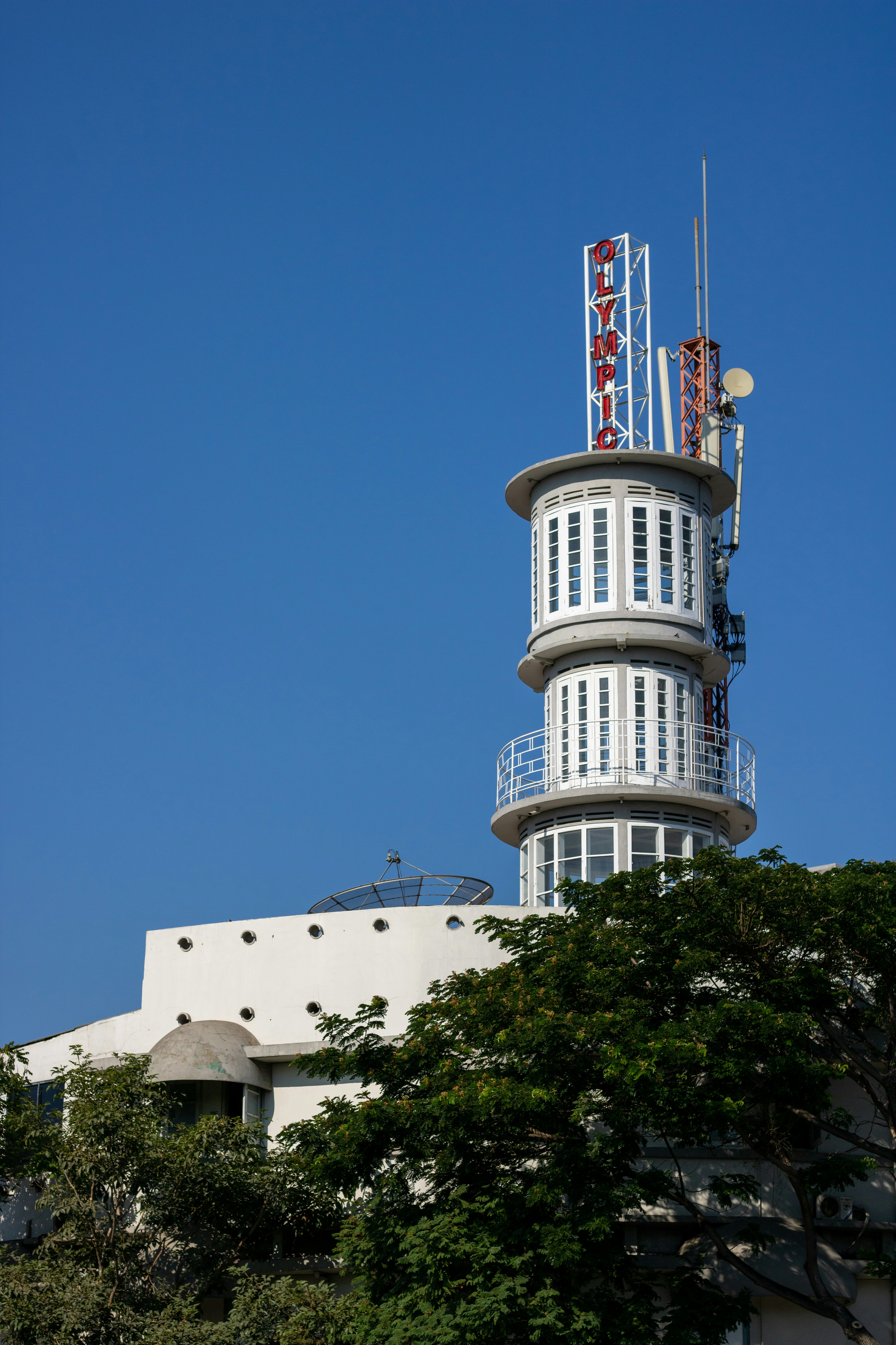 Cylindrical Spire Rising: A Retro Communications Tower Against a Clear Blue Sky