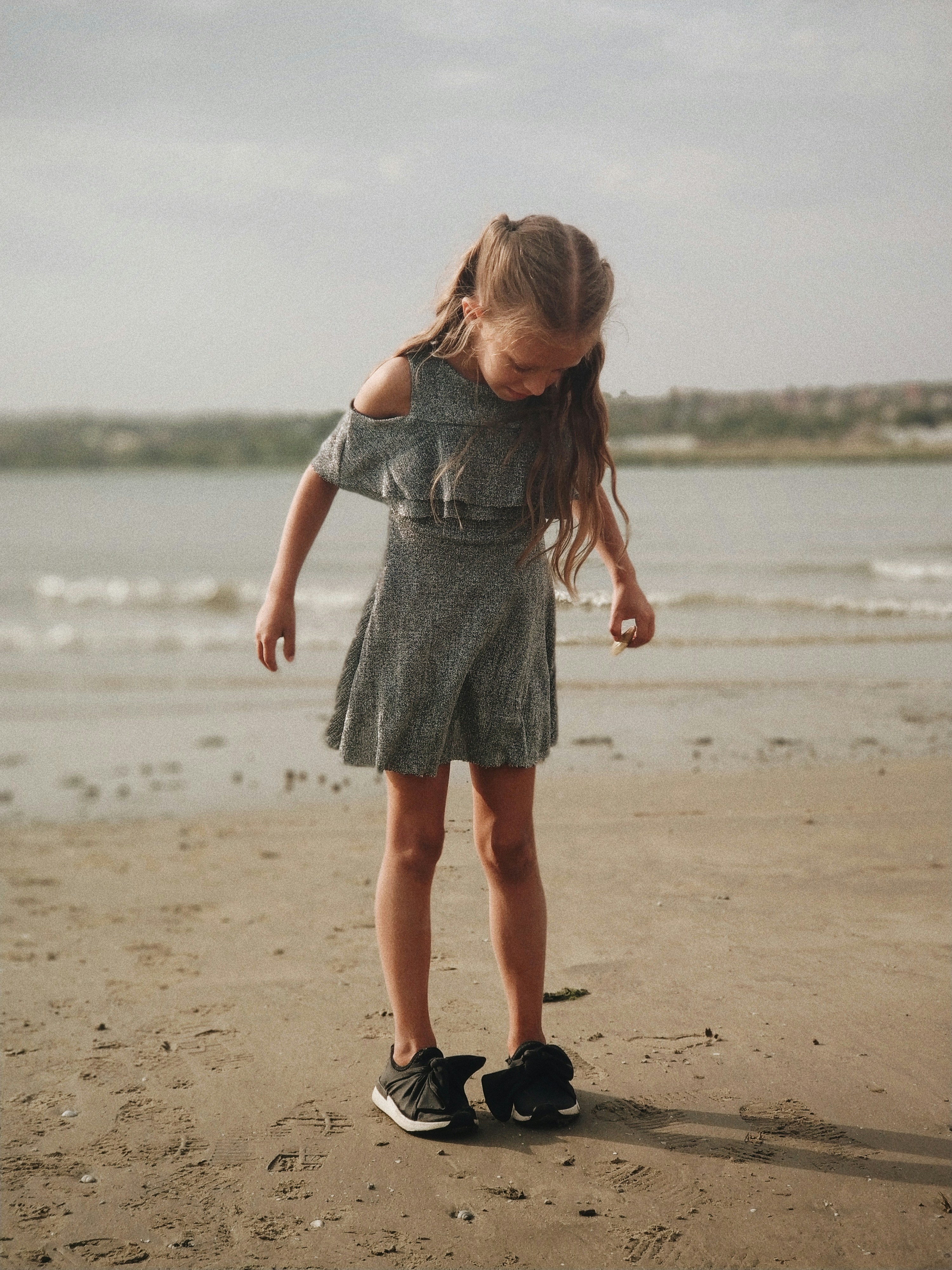 Girl in a Grey Dress at the Shore: A Quiet Moment on the Beach