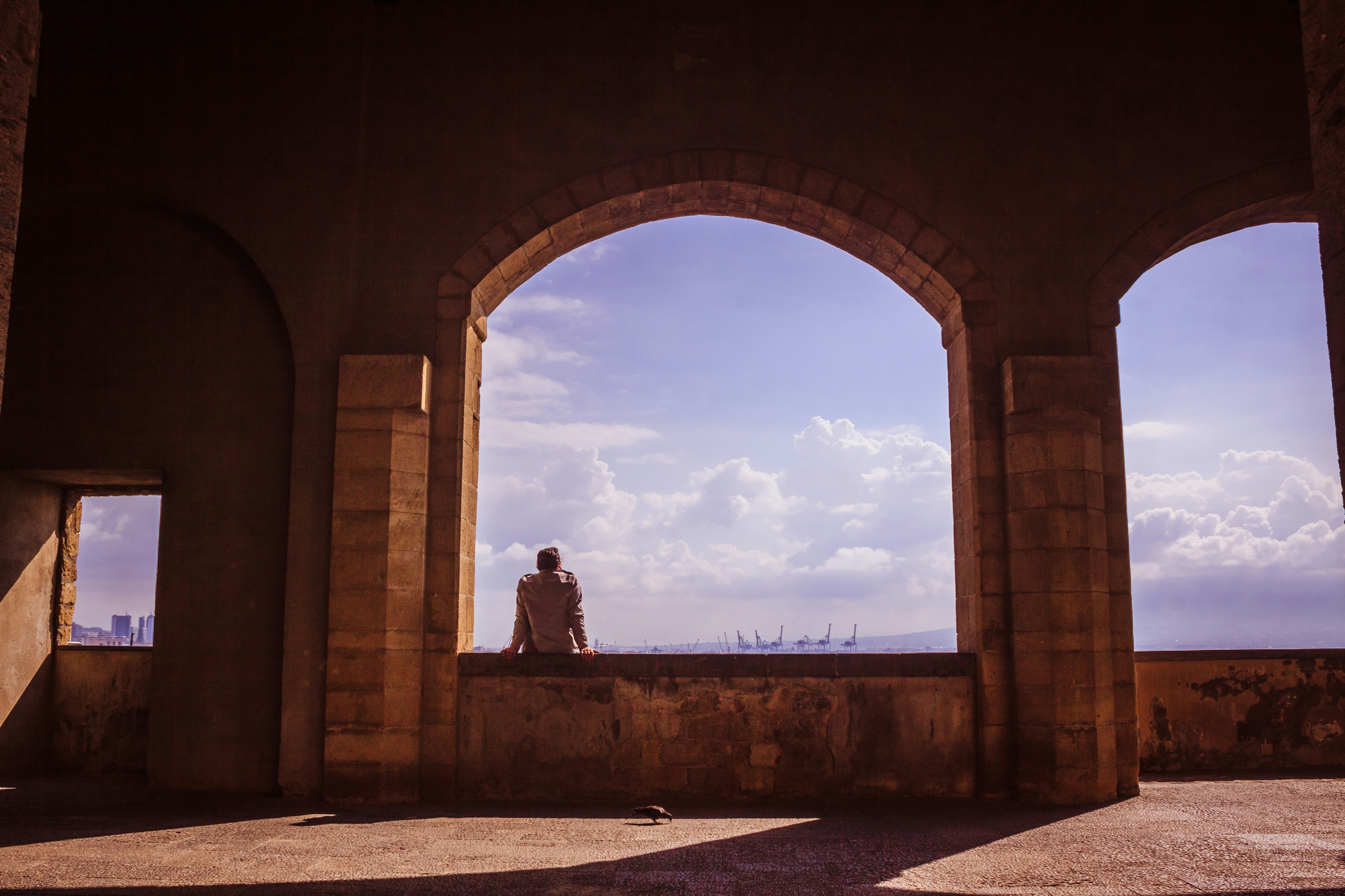 Persona sentada en la pared foto – Imagen de Edificio gratuita en Unsplash
