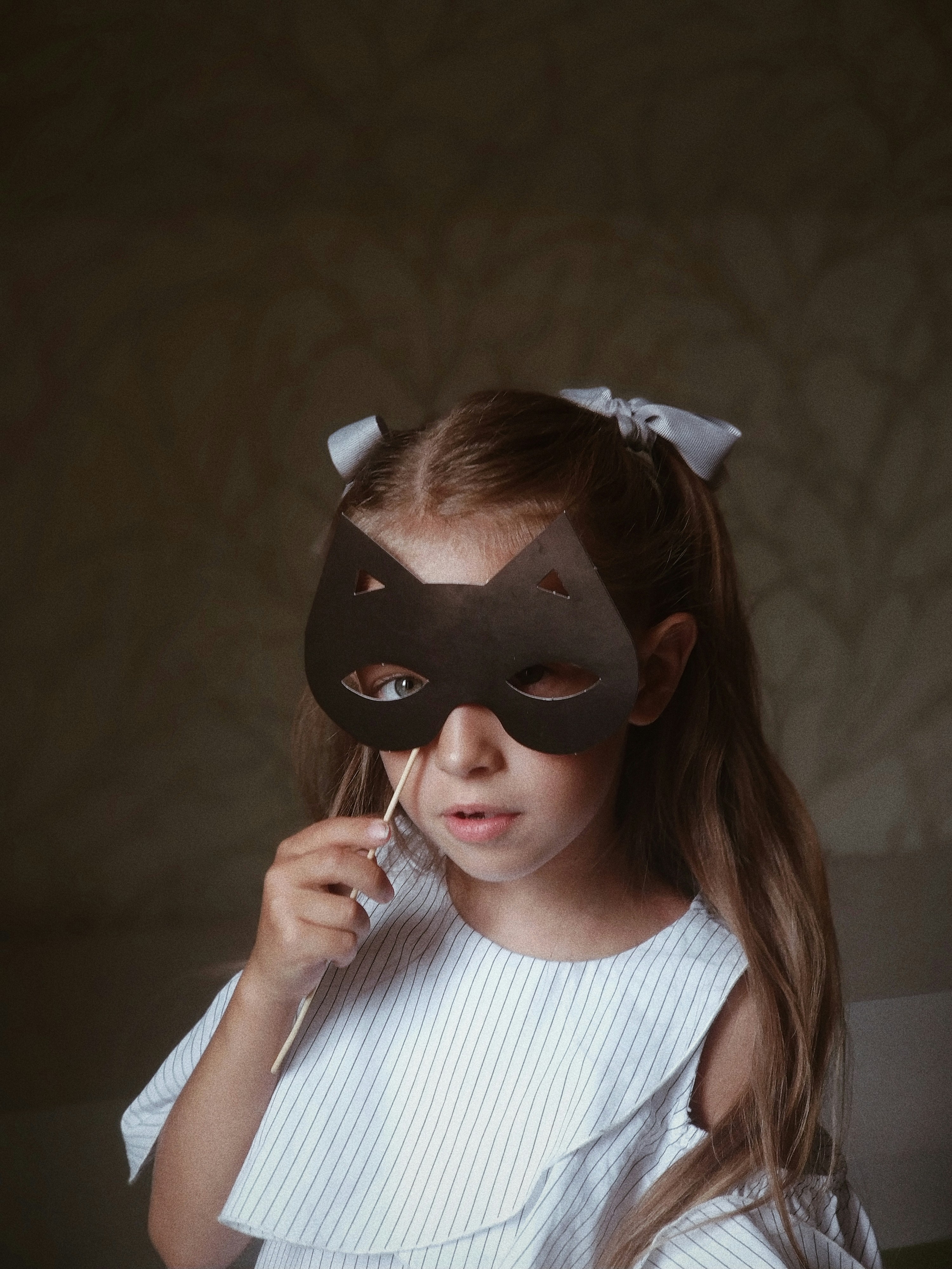 Mask and Mystery: A Girl with a Cardboard Cat-Eye Stare