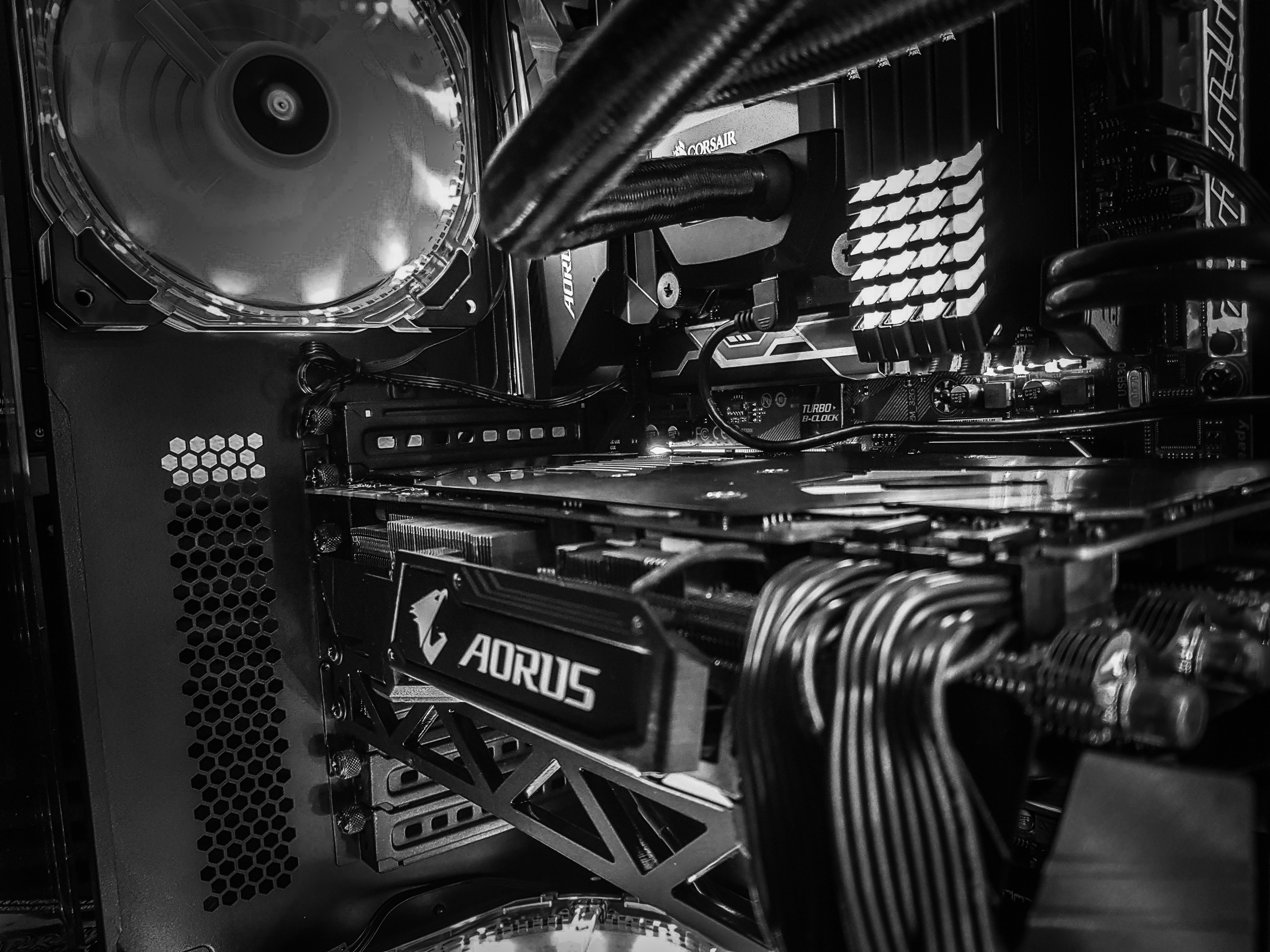 Monochrome close-up of a computer tower interior showcasing detailed cable management and components.