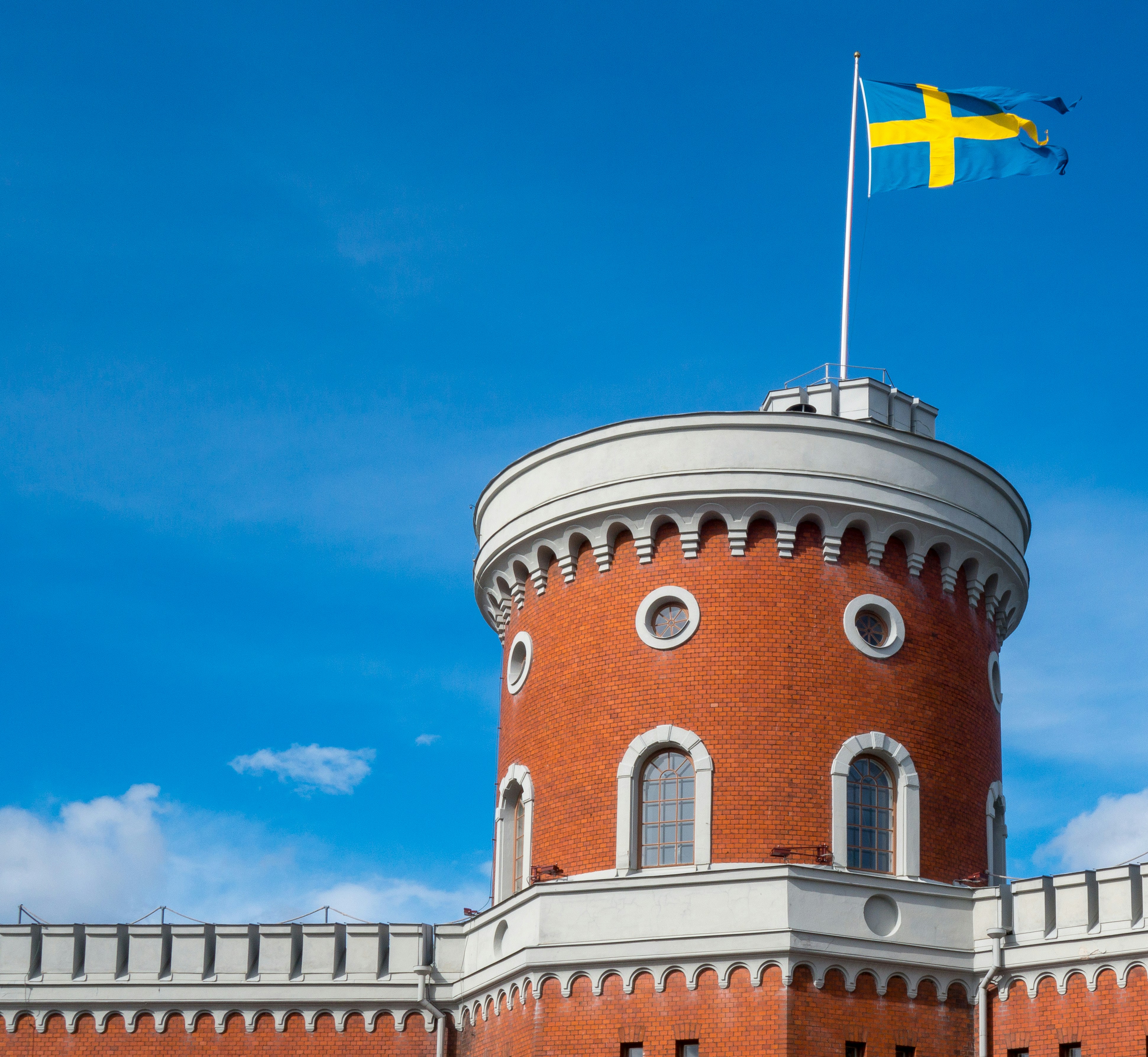 Flag over a brick bastion: urban fortress under a blue sky