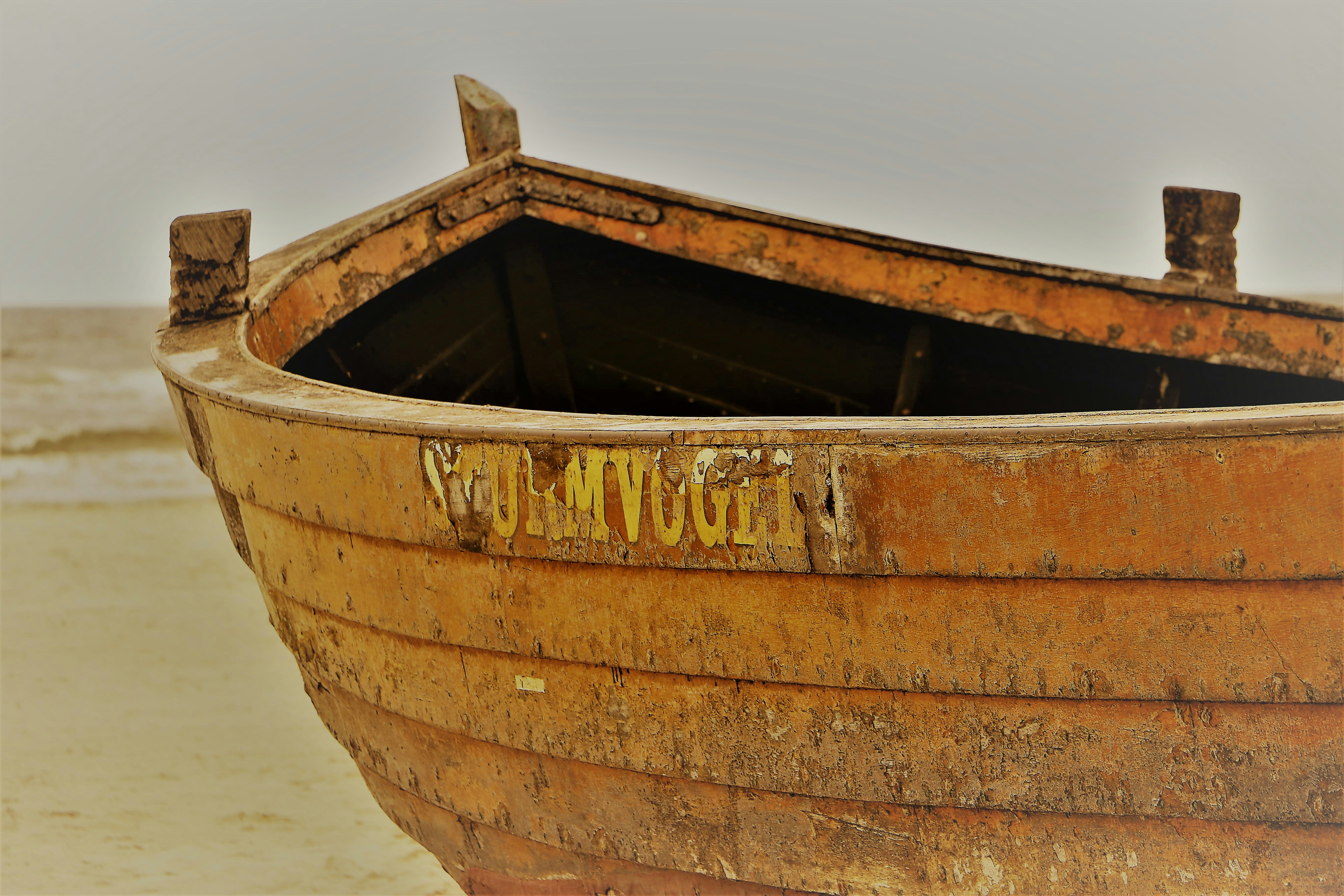 Rust-Burnished Rowboat on a Quiet, Wind-Washed Shore