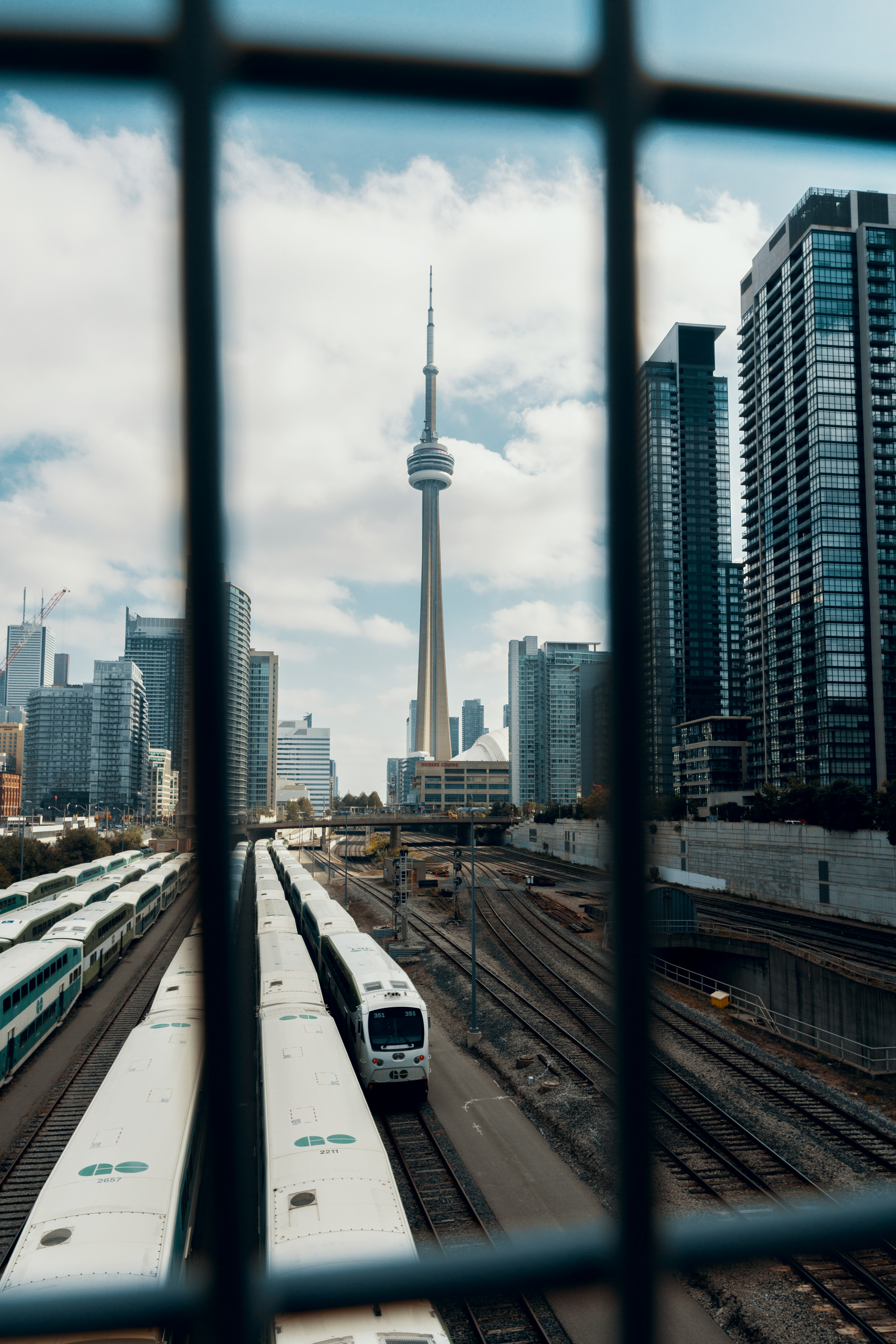 Tower through the Bars: Toronto Skyline Framed by Rails