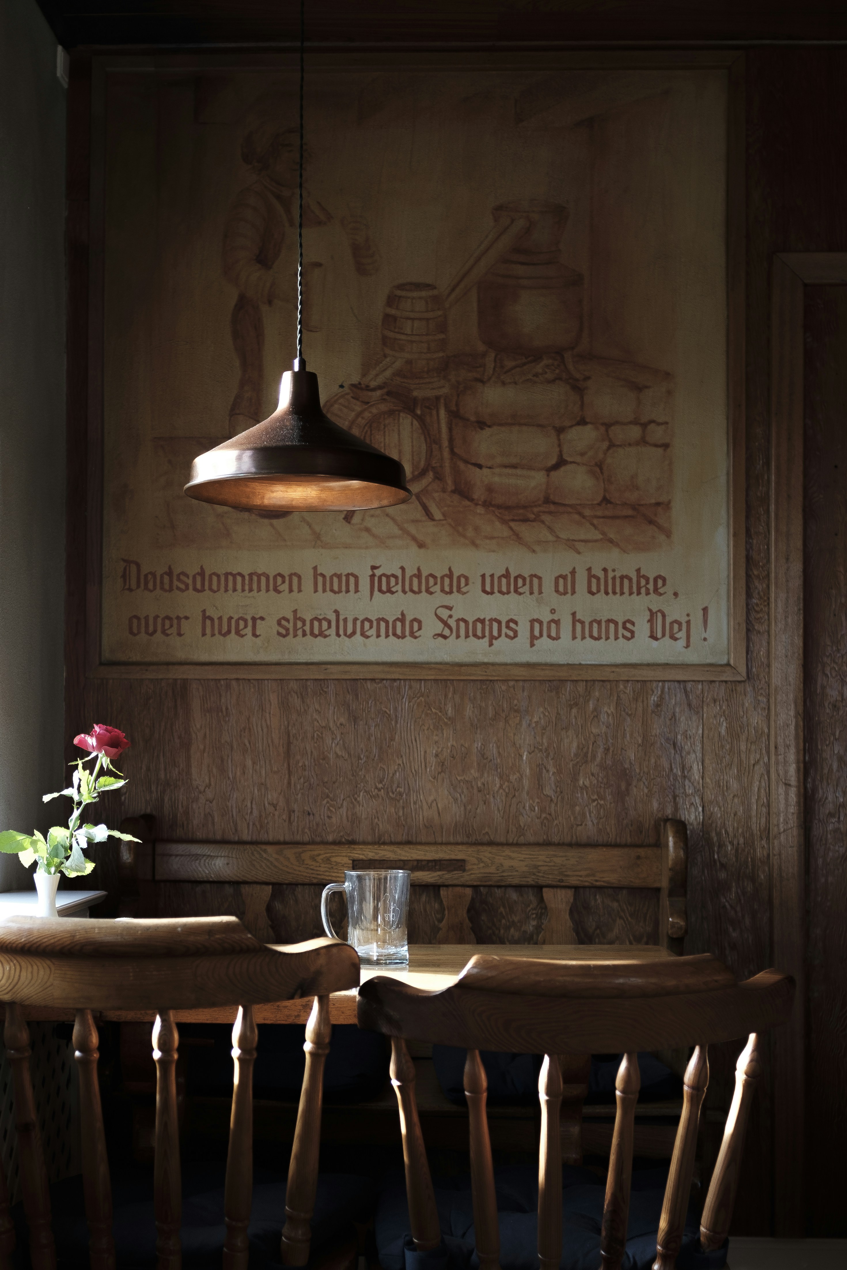 Dim-lit Café Portrait: An Olive-wood Ambience with a Lone Rose