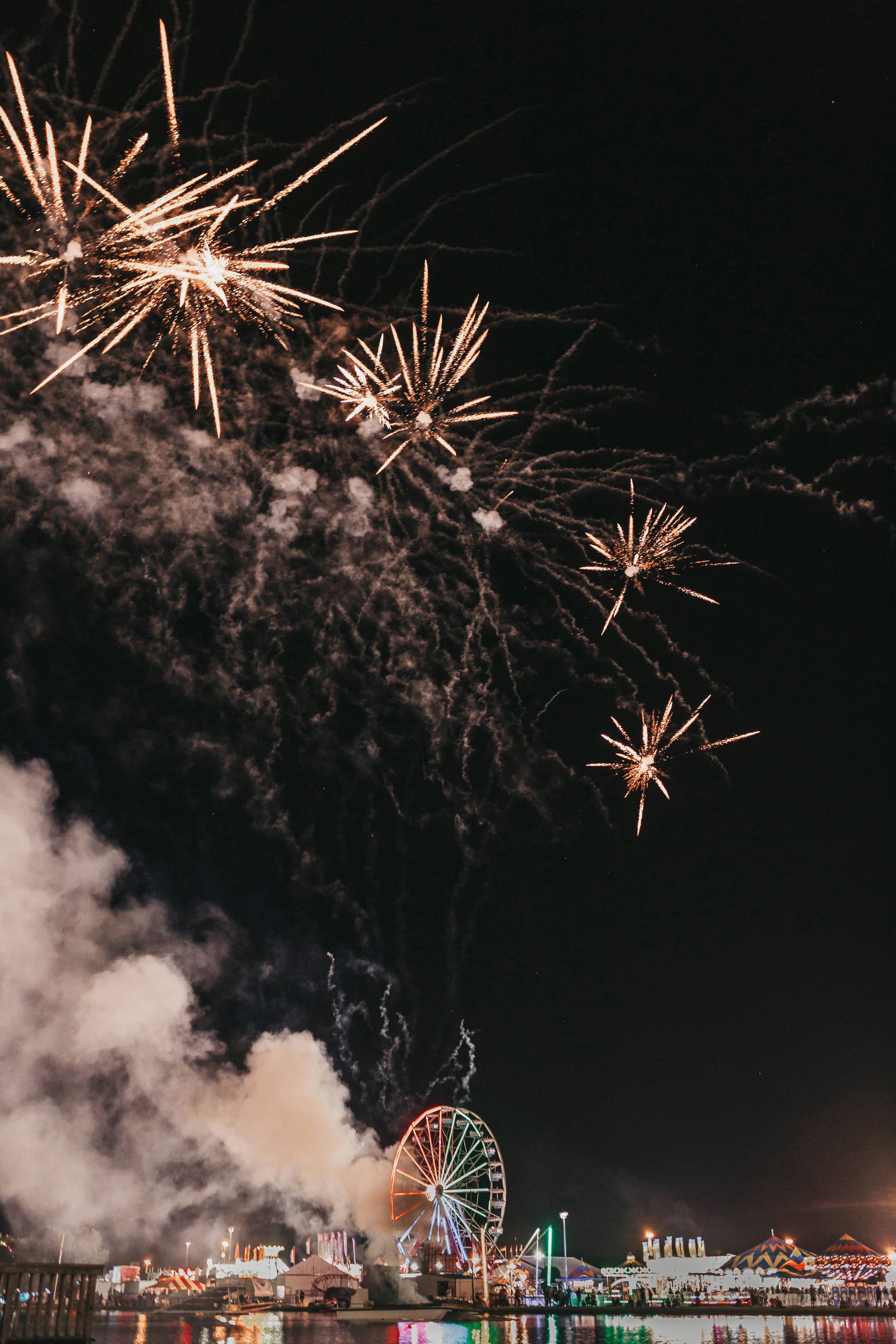 Night Sky Burst Over a Lively Seaside Funfair