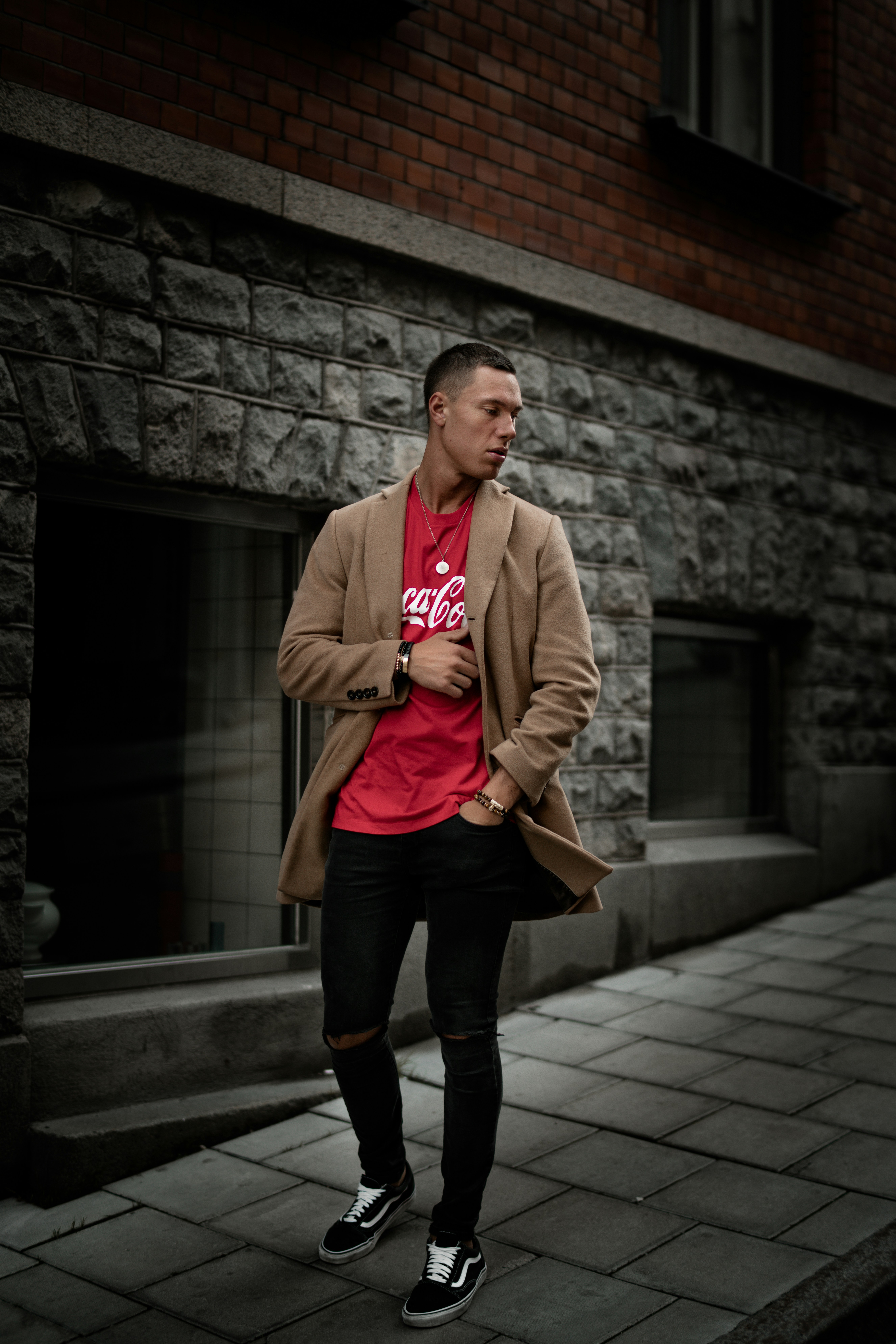 City Quiet: Portrait of a Man in a Camel Coat Beneath a Weathered Urban Façade