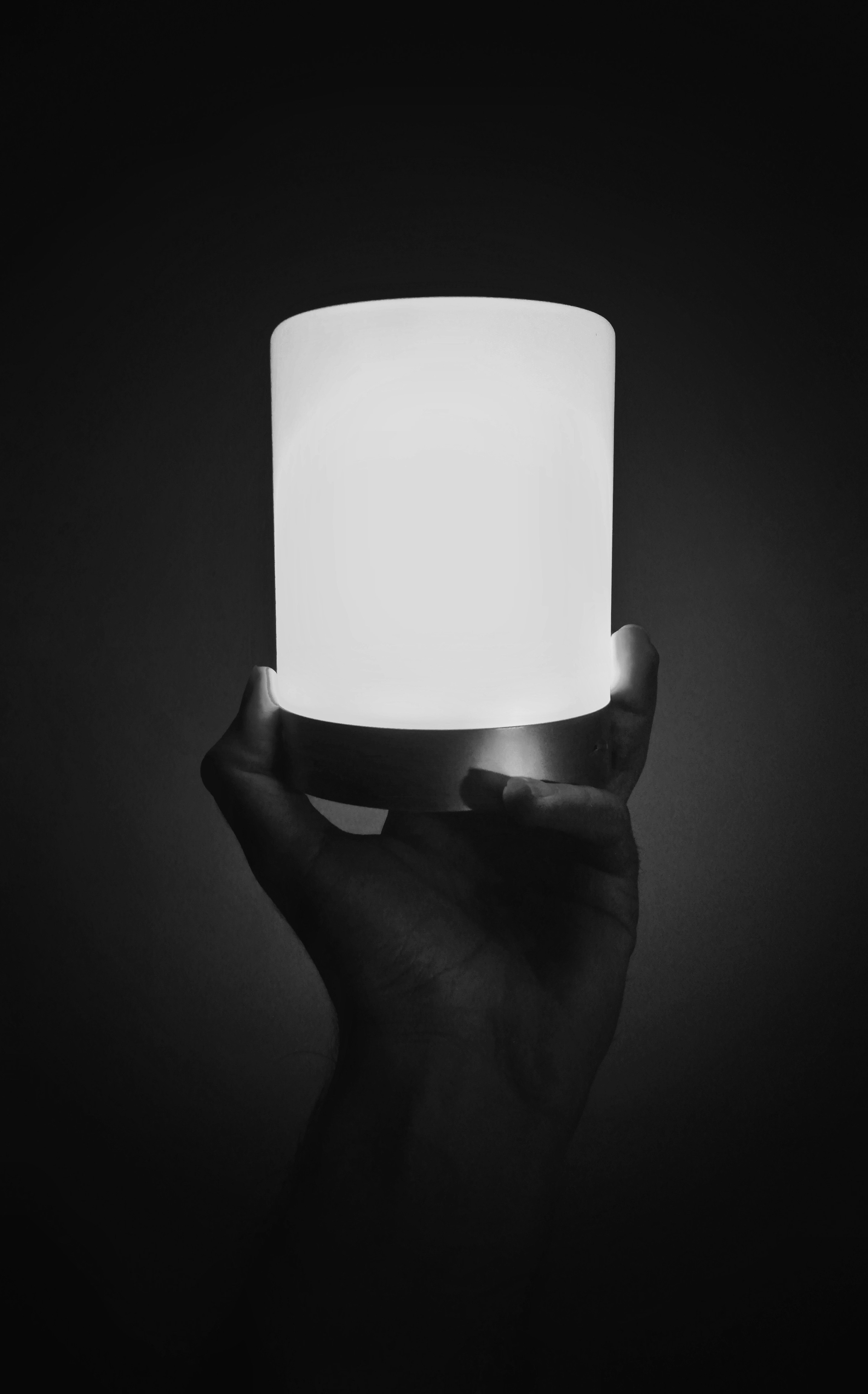 Luminescent Grip: A Quiet Hand Holds a Soft Cylinder of Light