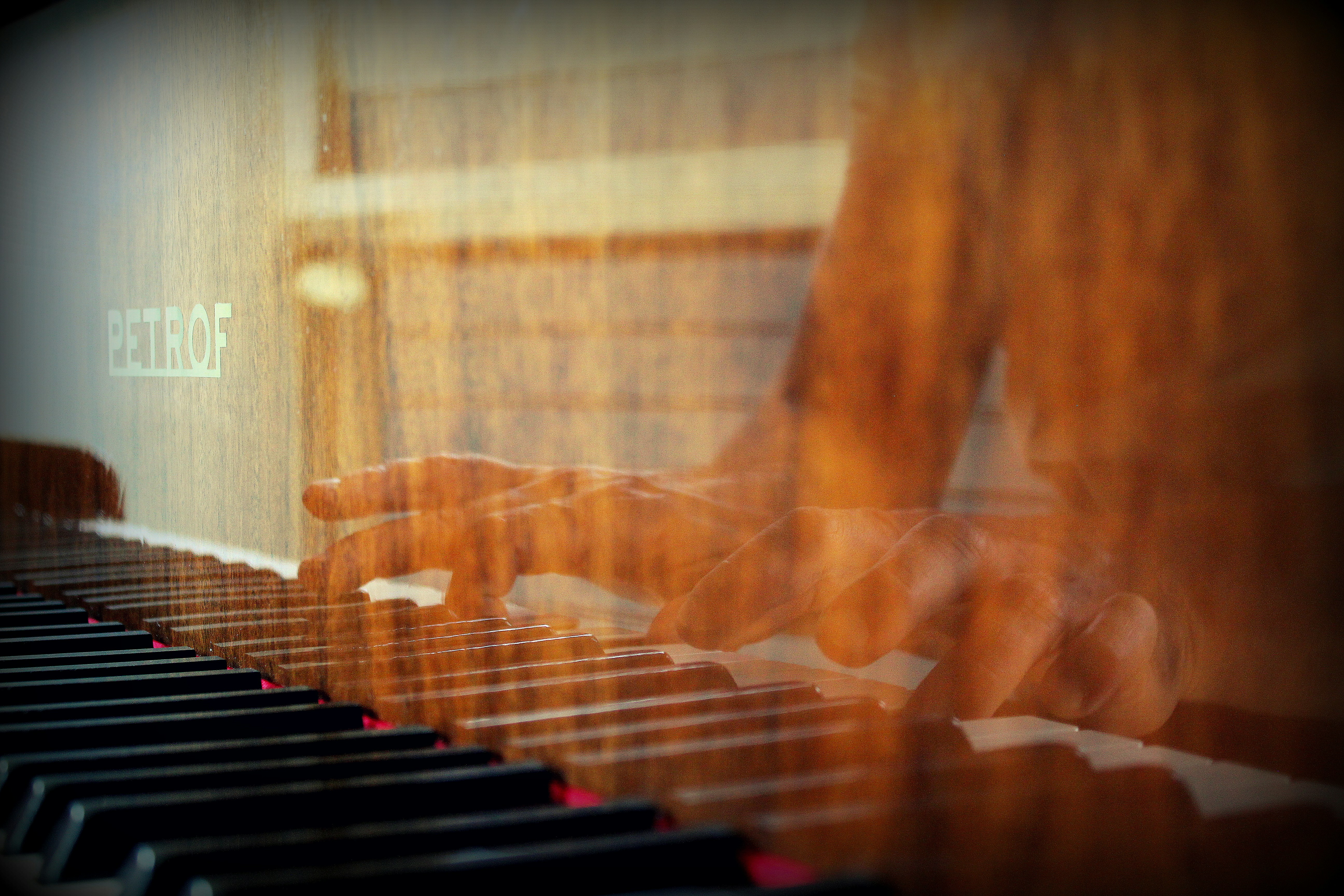 Double-Exposure Serenade: Hands in Motion Across a Warm Piano