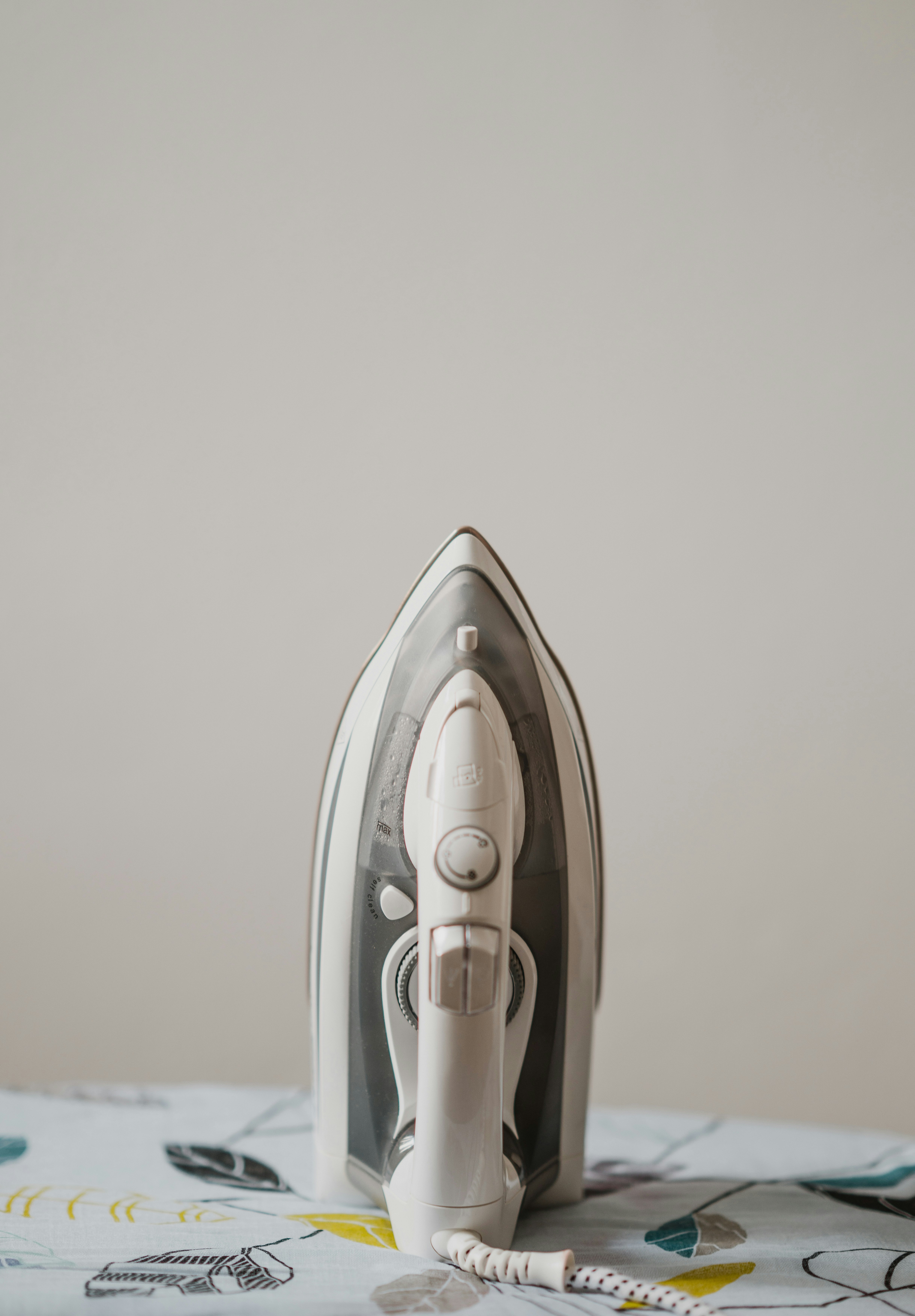 Iron on ironing board | used white and gray steam iron