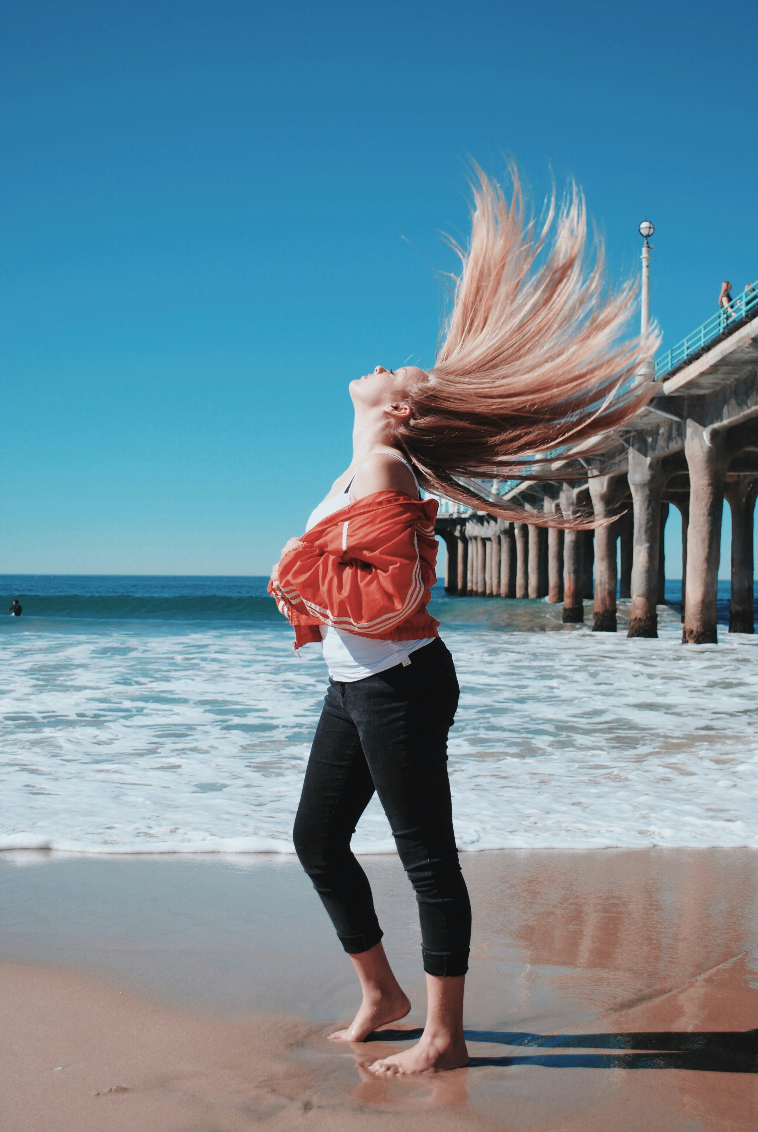 Hair in Flight at the Pier: A Beach Portrait with Wind and Waves