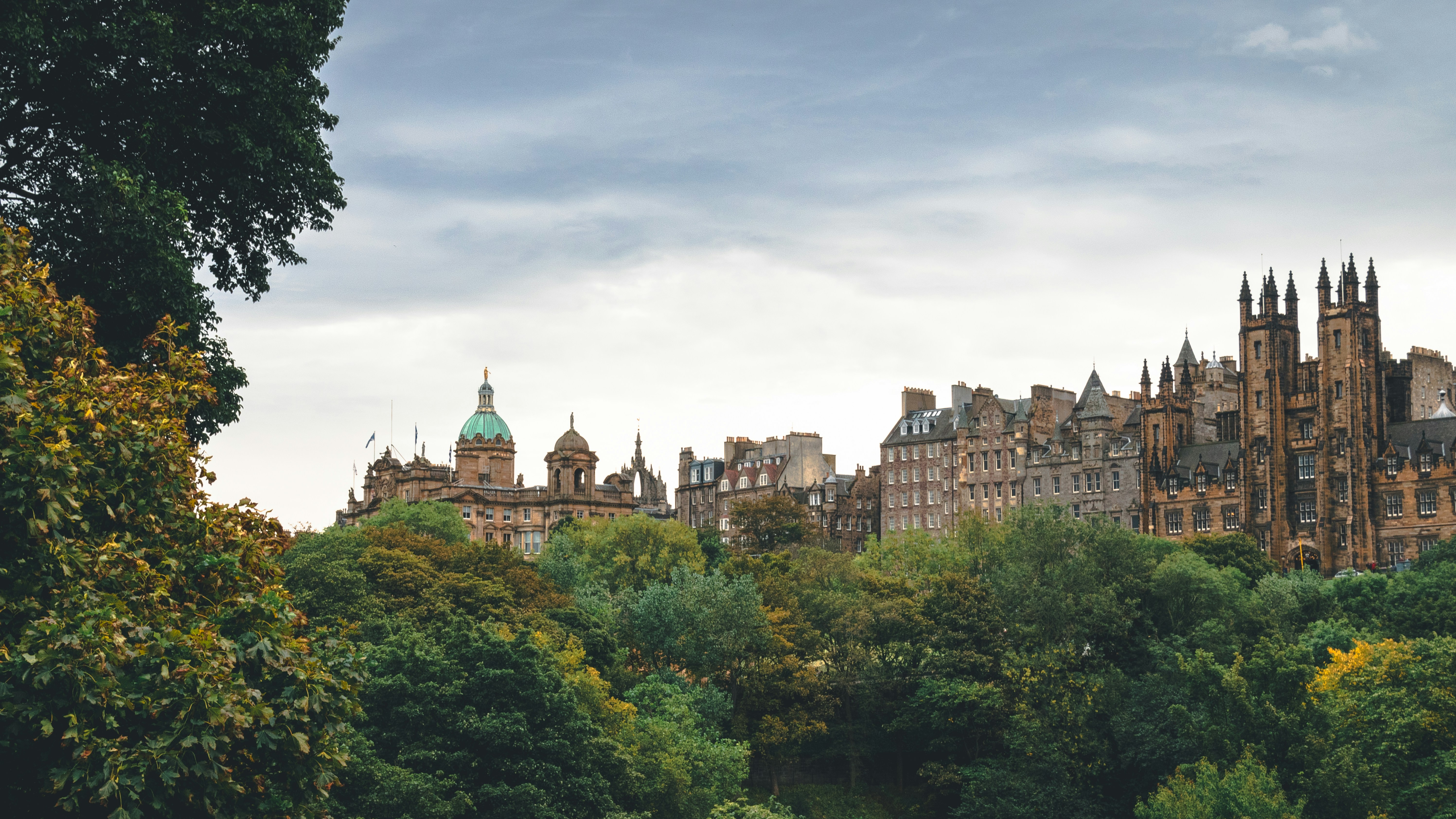 Took this photo during my trip to Edinburgh with my girlfriend. Just lov these old tall buildings and also lots of greenery everywhere. The weather was constantly changing so I was pretty lucky to take this photo before it started to rain. | beige castle near trees during daytime