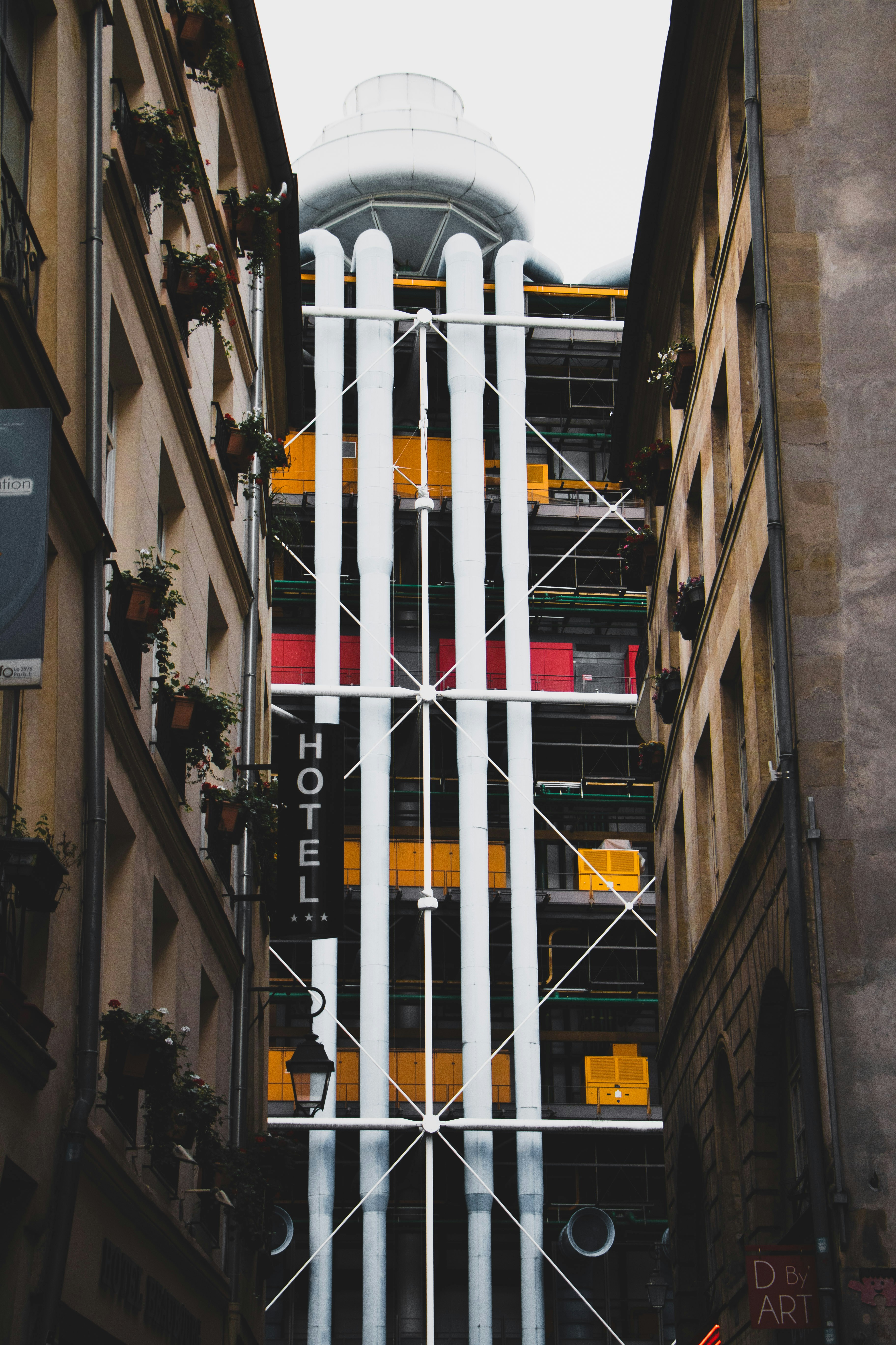 Pipes Over the Alley: A Modern Facade Rising Between Historic Walls
