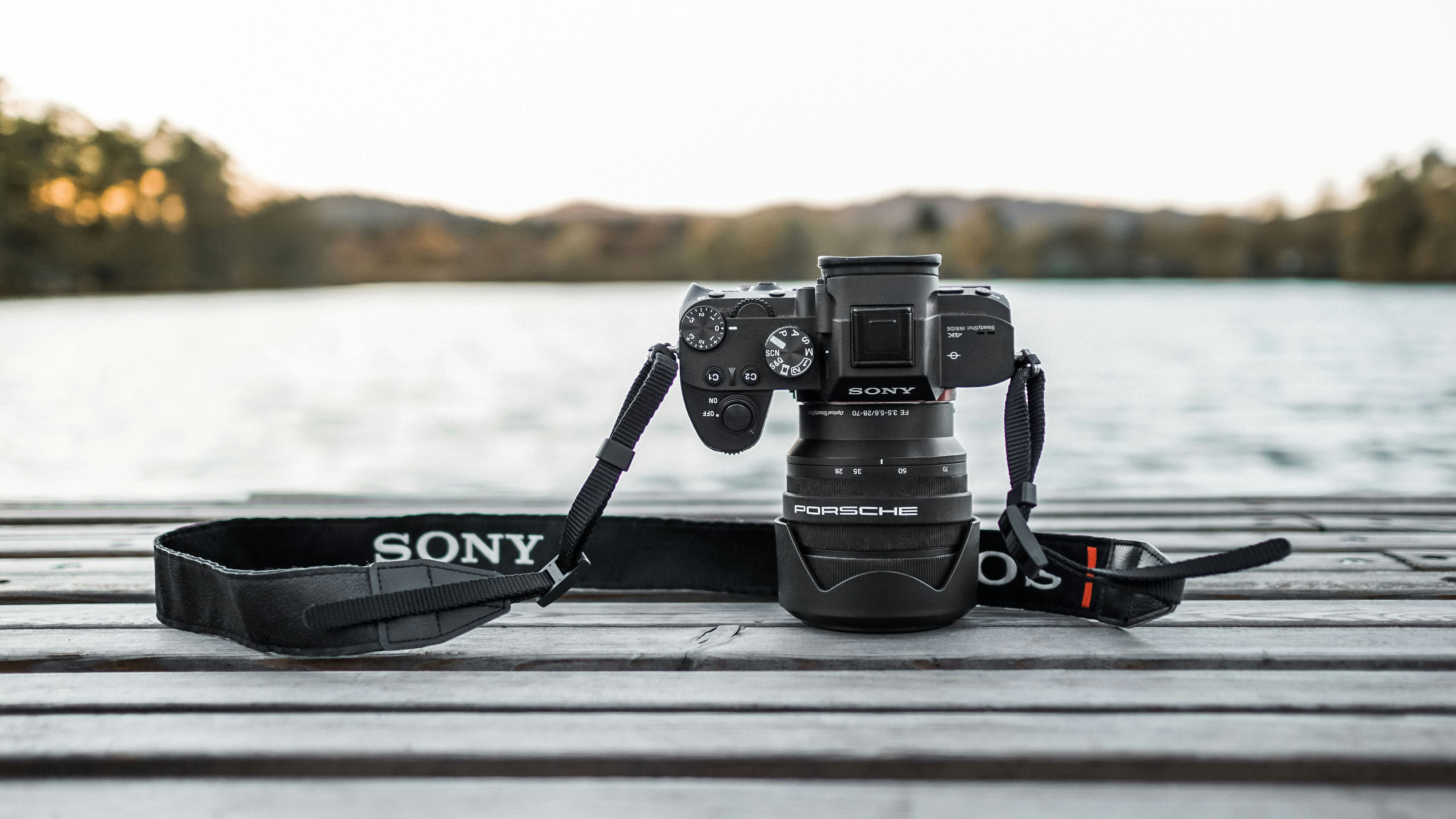 Black Sony camera face down on panel by body of water photo – Free ...