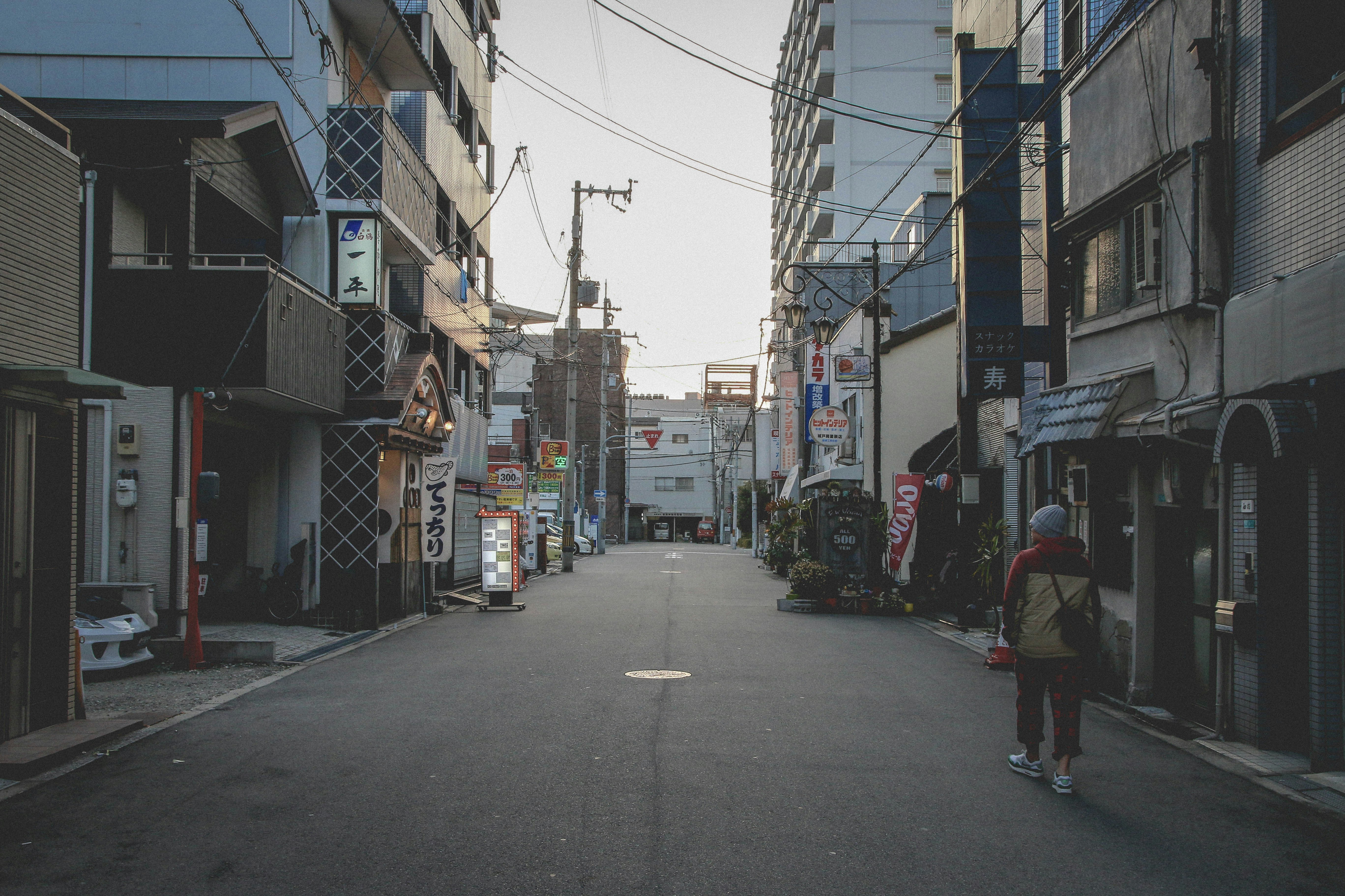 Person walking between two buildings photo – Free Grey Image on Unsplash