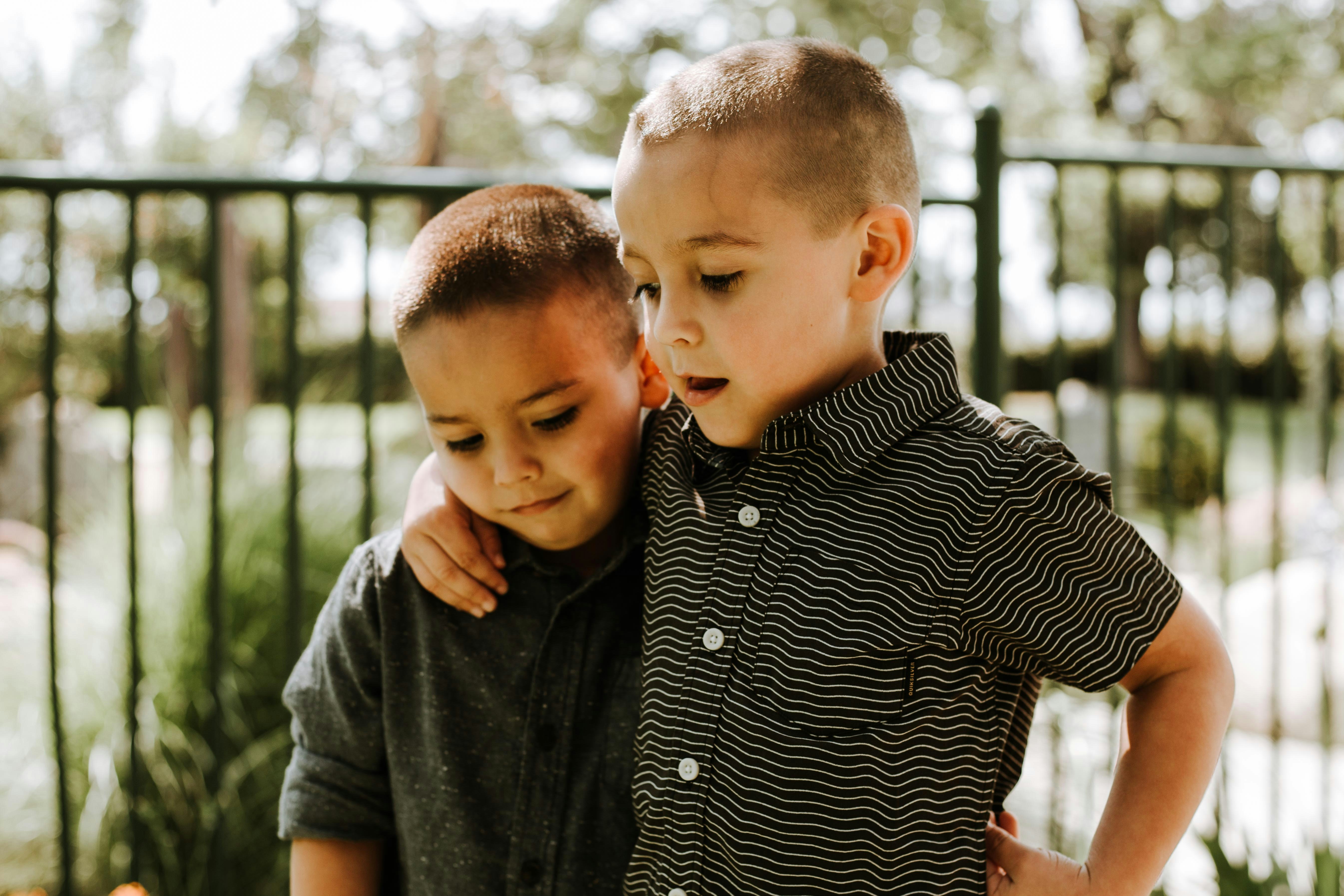 Two toddlers standing near black metal railing photo – Free Human Image ...