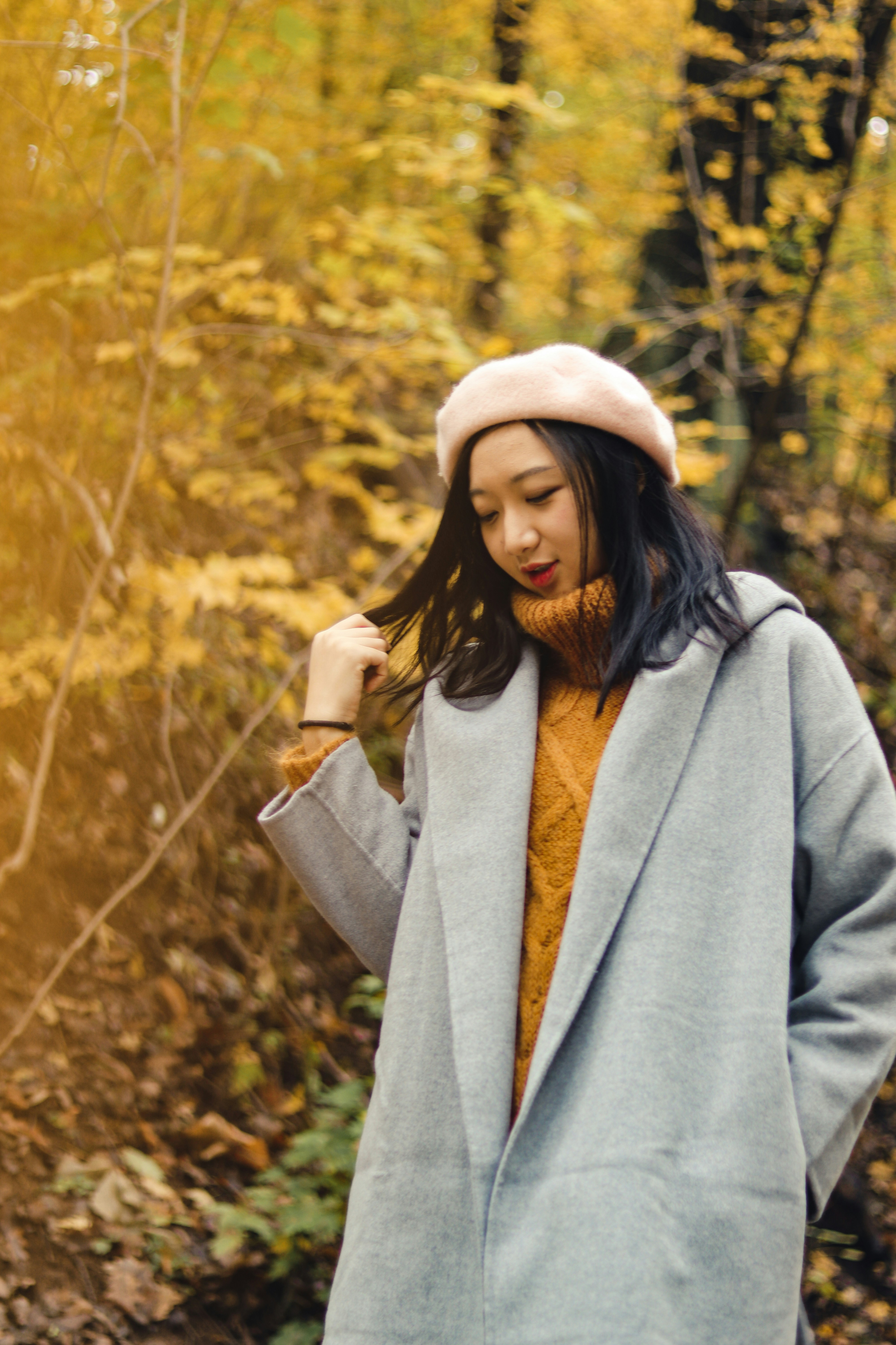Trying to capture the fall before it is gone. | woman wearing grey coat and pink hat
