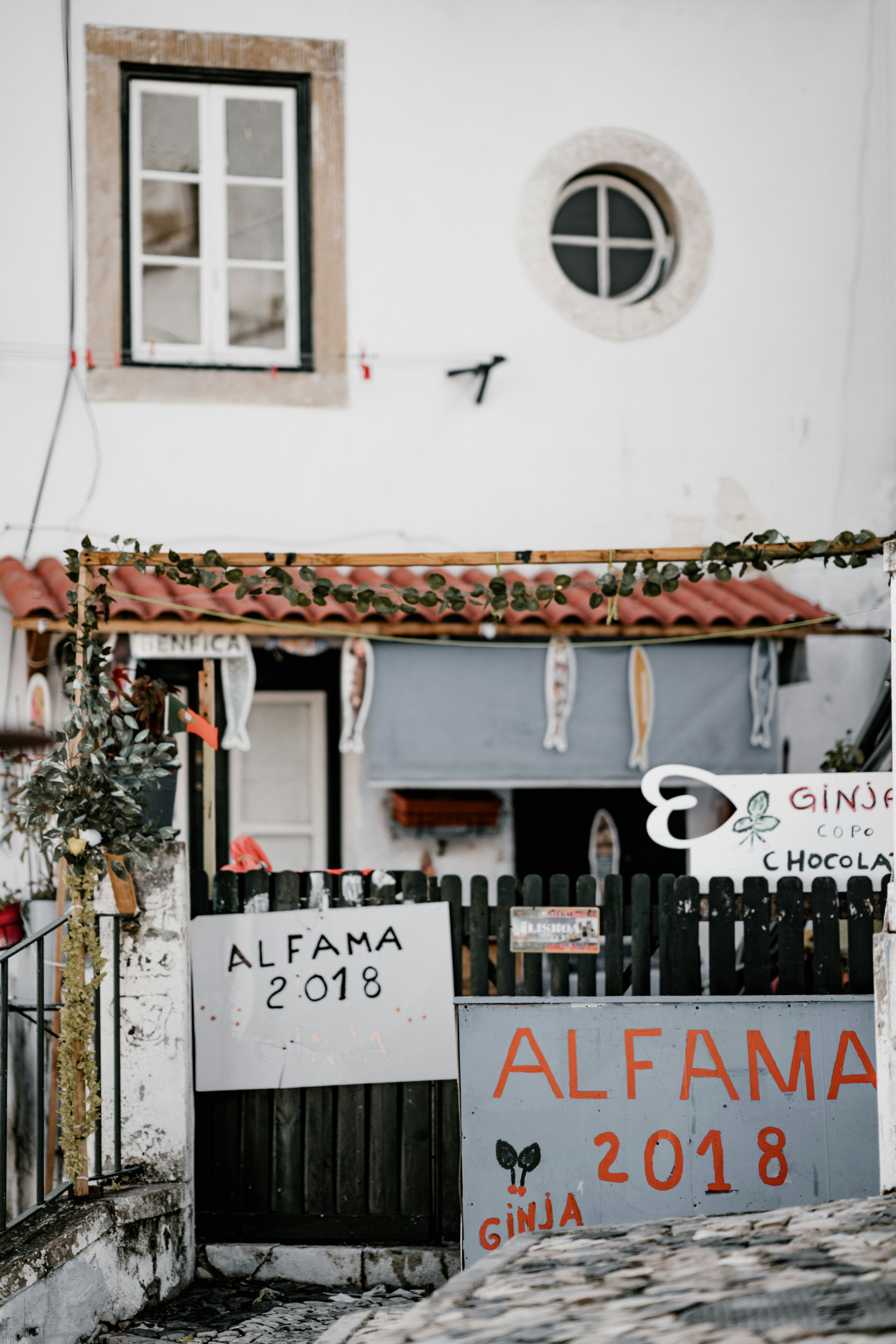 Colorful signs adorn a gate in Lisbon's historic Alfama district, promoting local festivities.