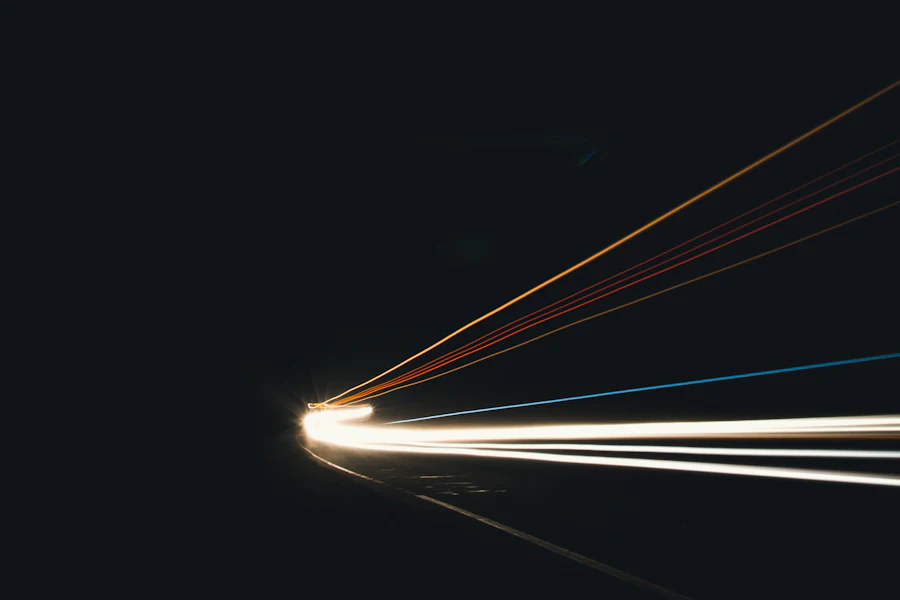 Bright streaks of light curve and stream across a nearly black scene, converging near the lower left. Orange, white, and blue lines create a sense of motion through darkness.