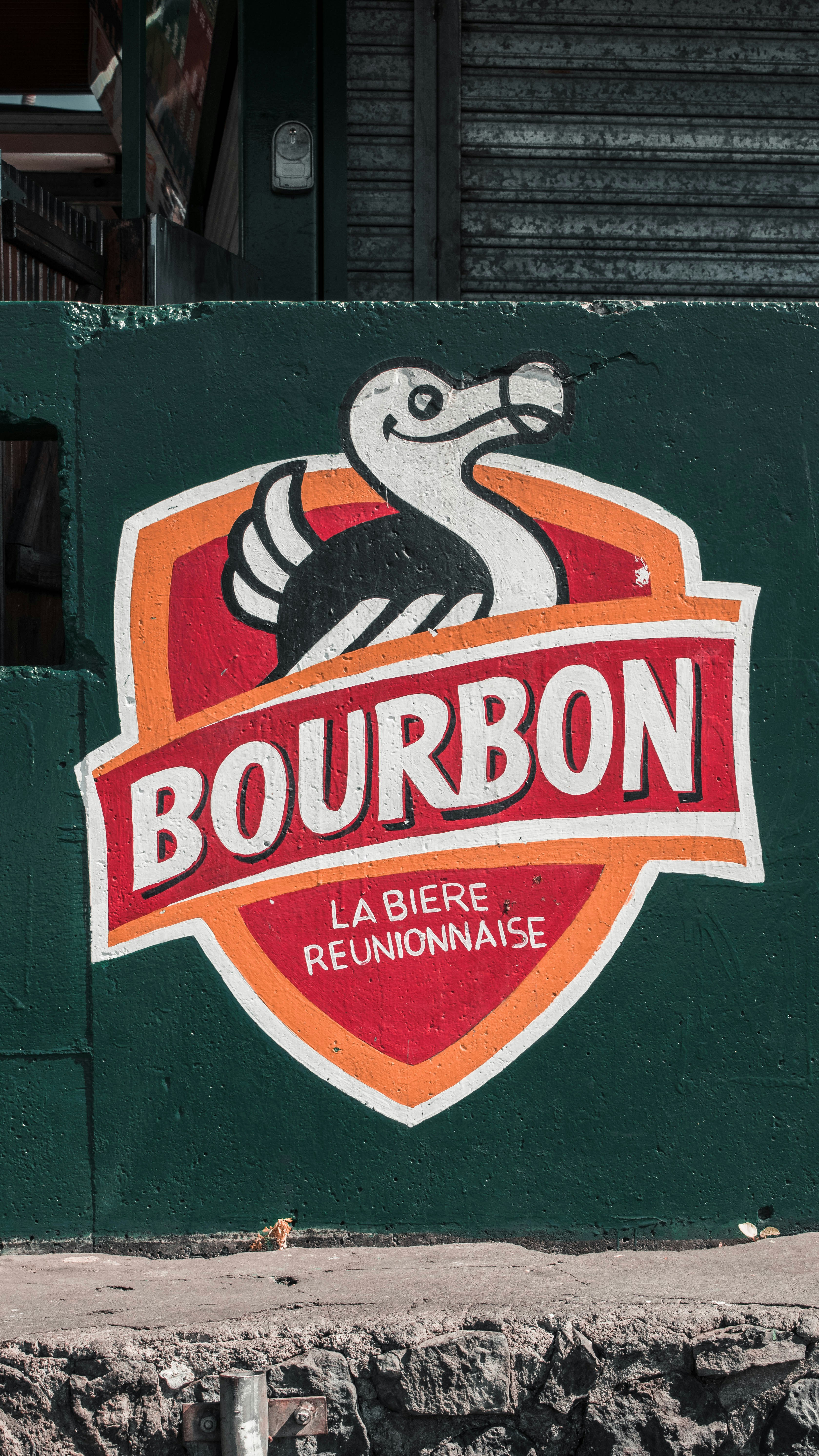 Heraldic Duck Crest: Bourbon Graffiti on a Weathered Green Wall