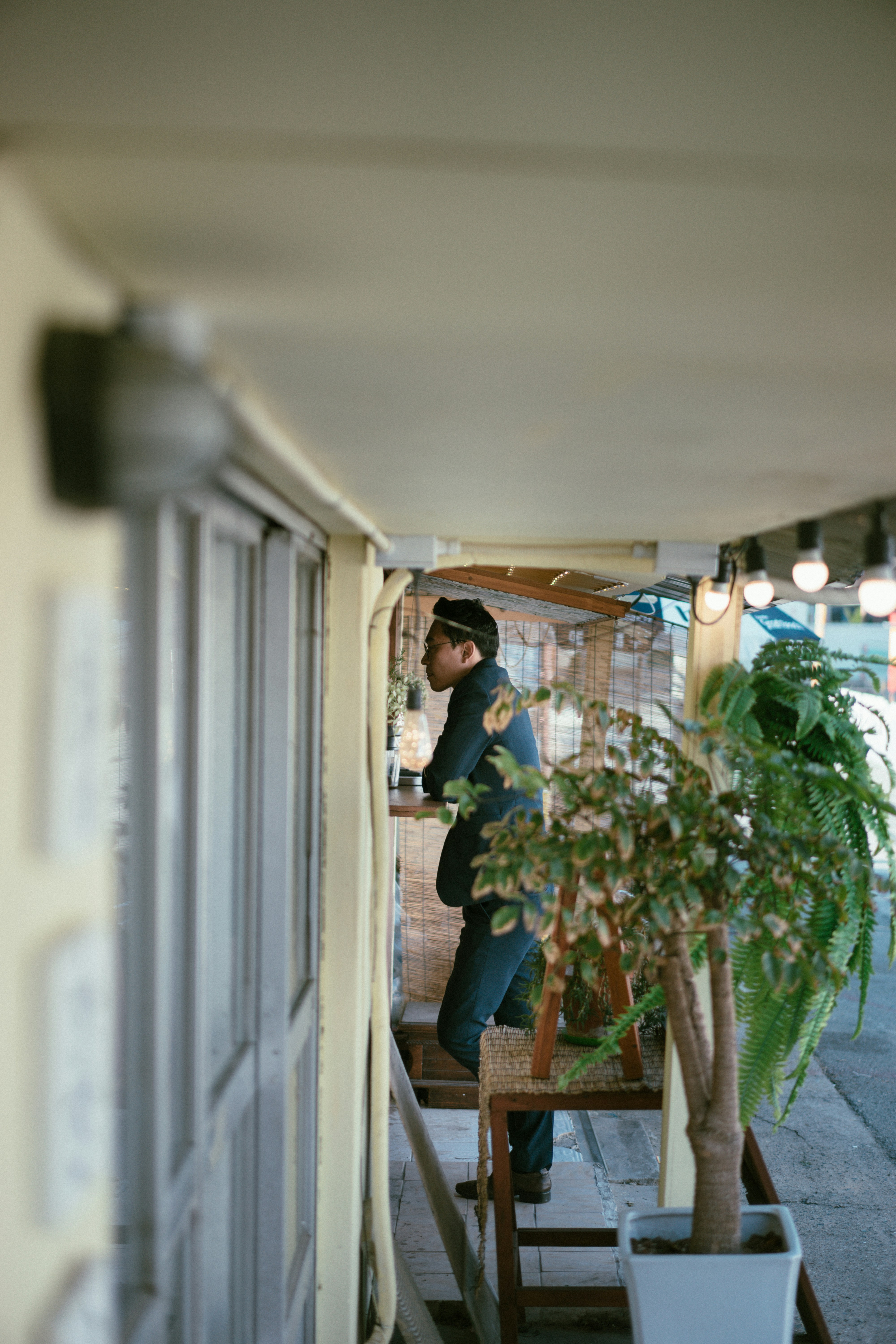 Suit in the Alley Café: Quiet Moment Among Greenery and Soft Lights