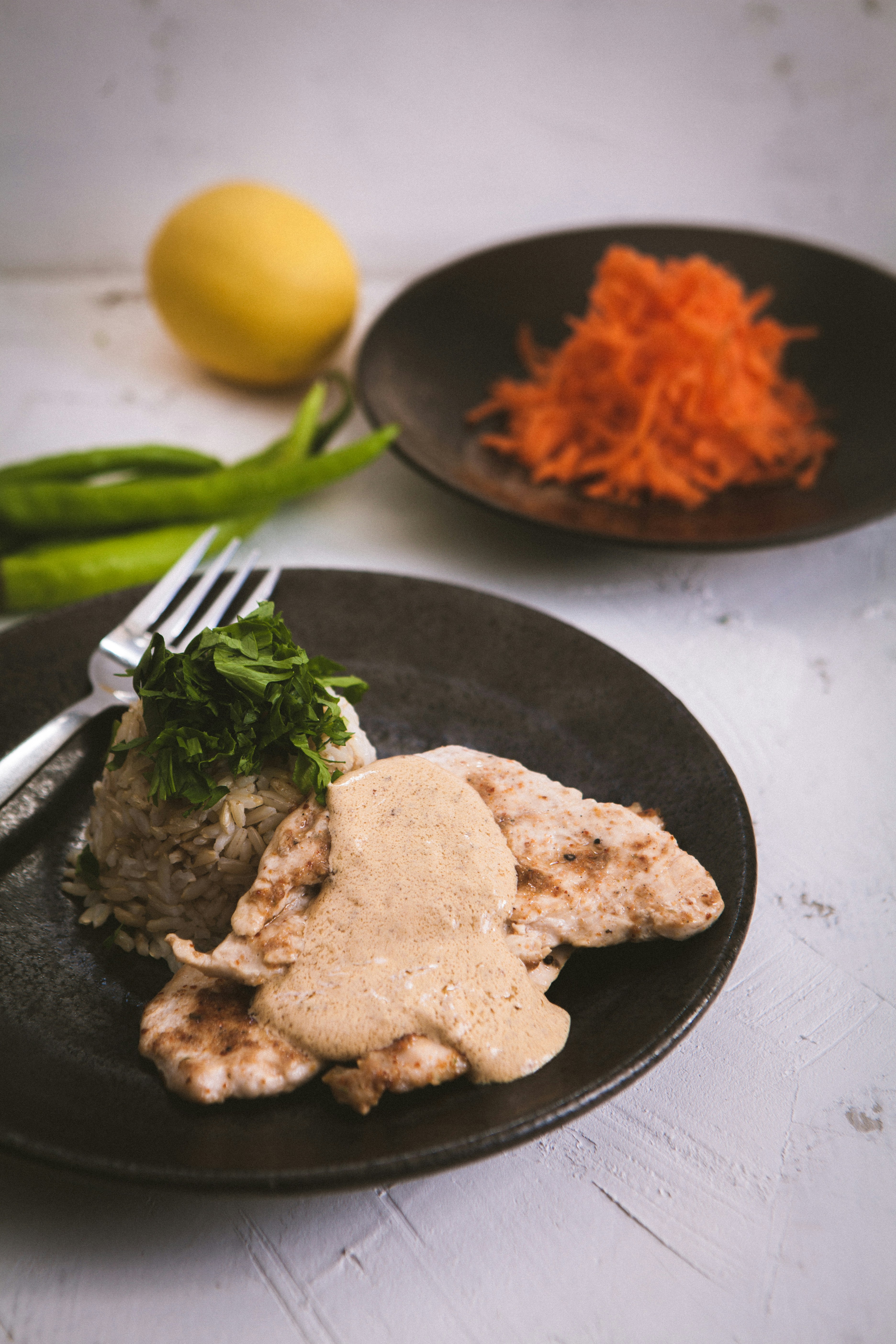 Herb-Garnished Chicken Over Creamy Sauce on a Bed of Rice
