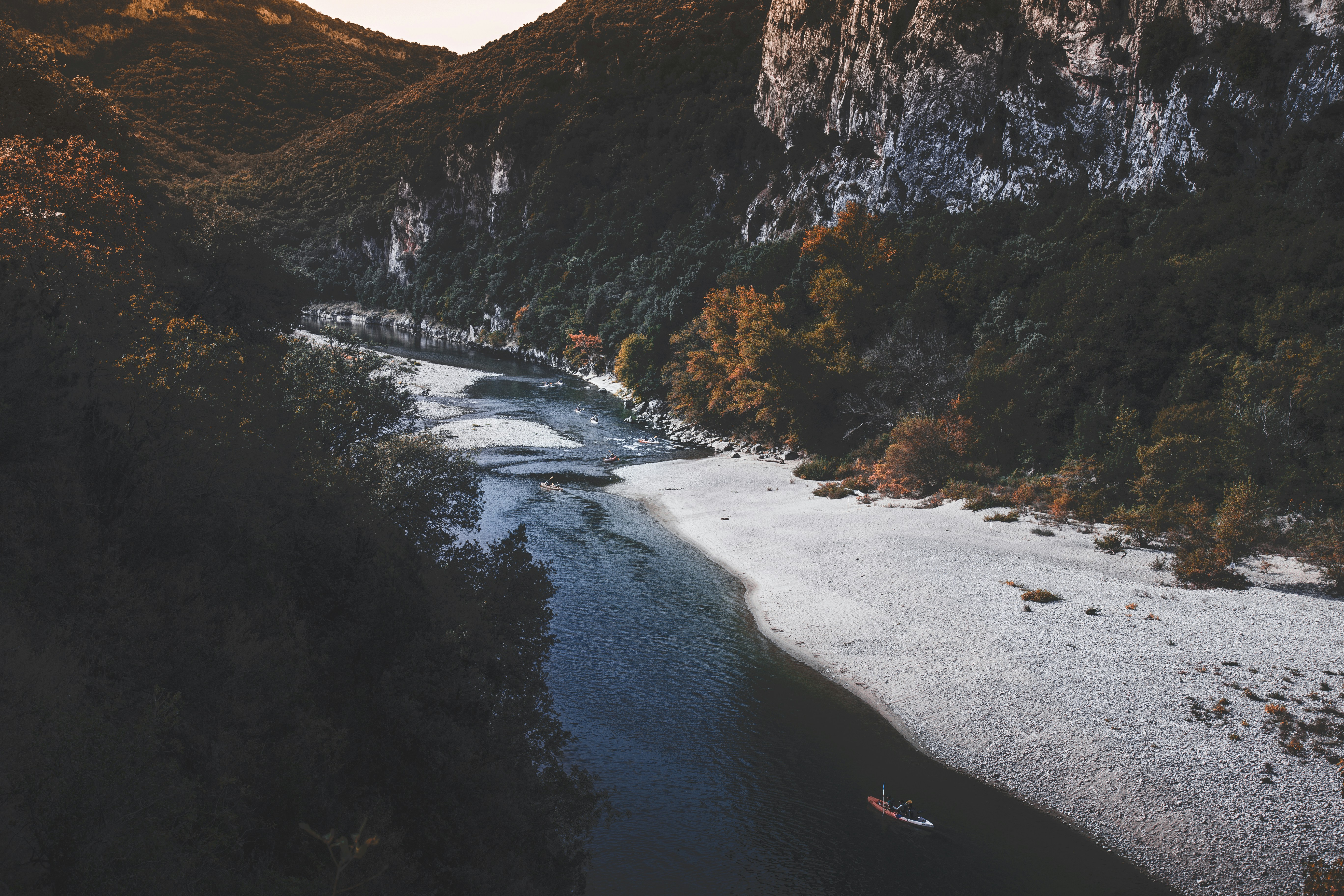 Serpentine Autumn: A lone kayaker threads the cliff-lined river